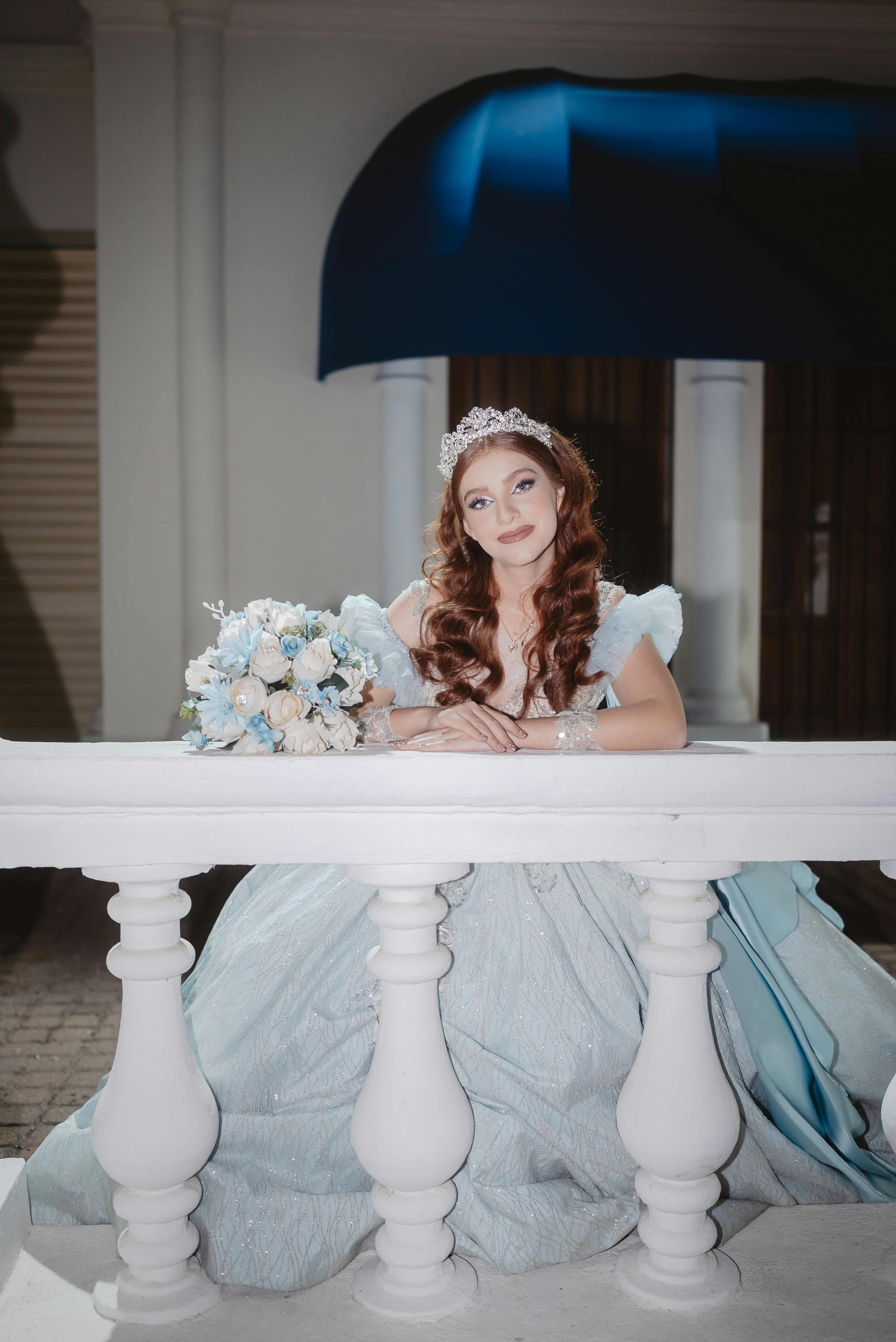 Young woman in a blue gown with a bouquet.