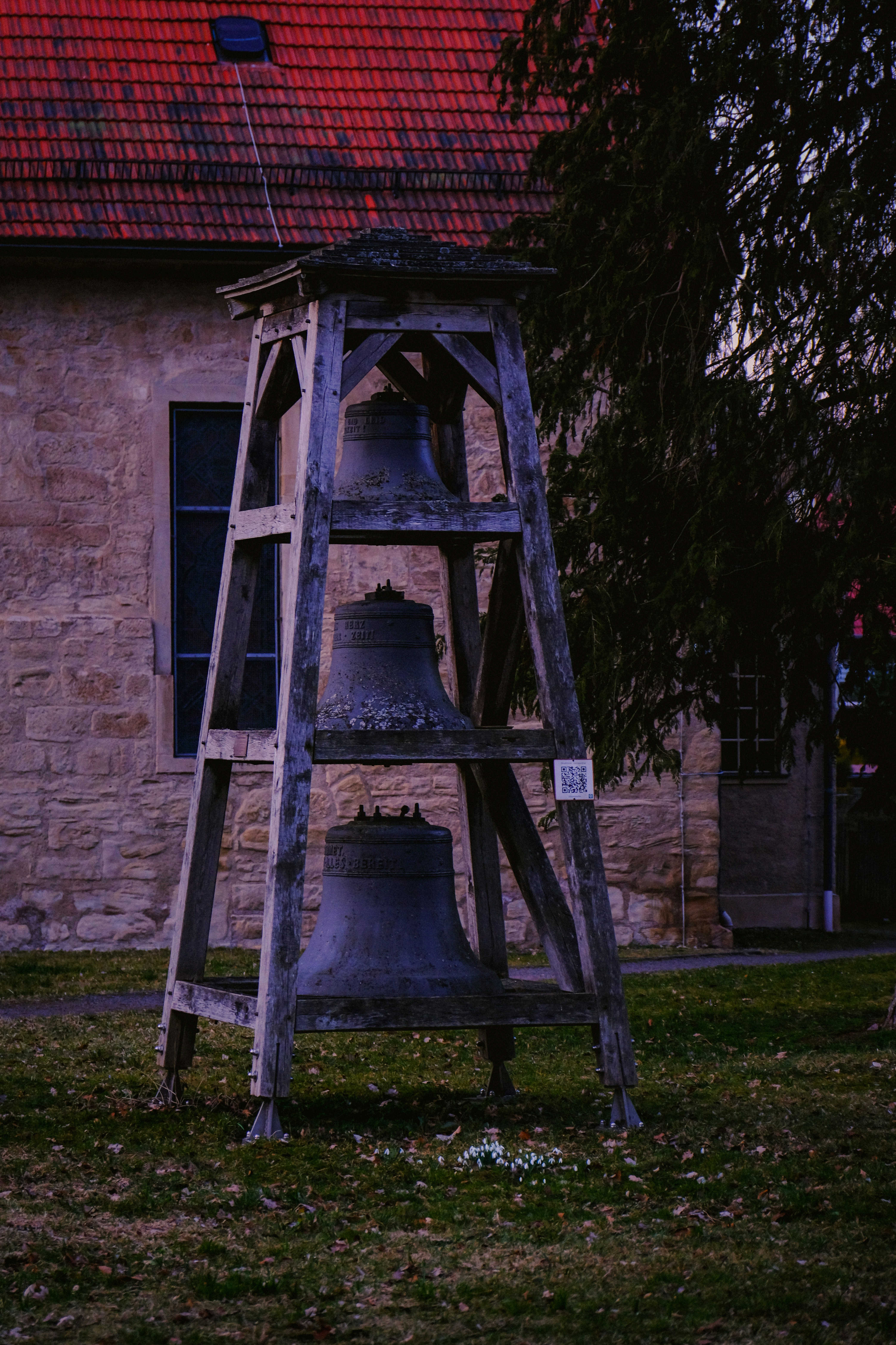 Timeworn bells under twilight: a rustic bell tower frames a weathered campus scene