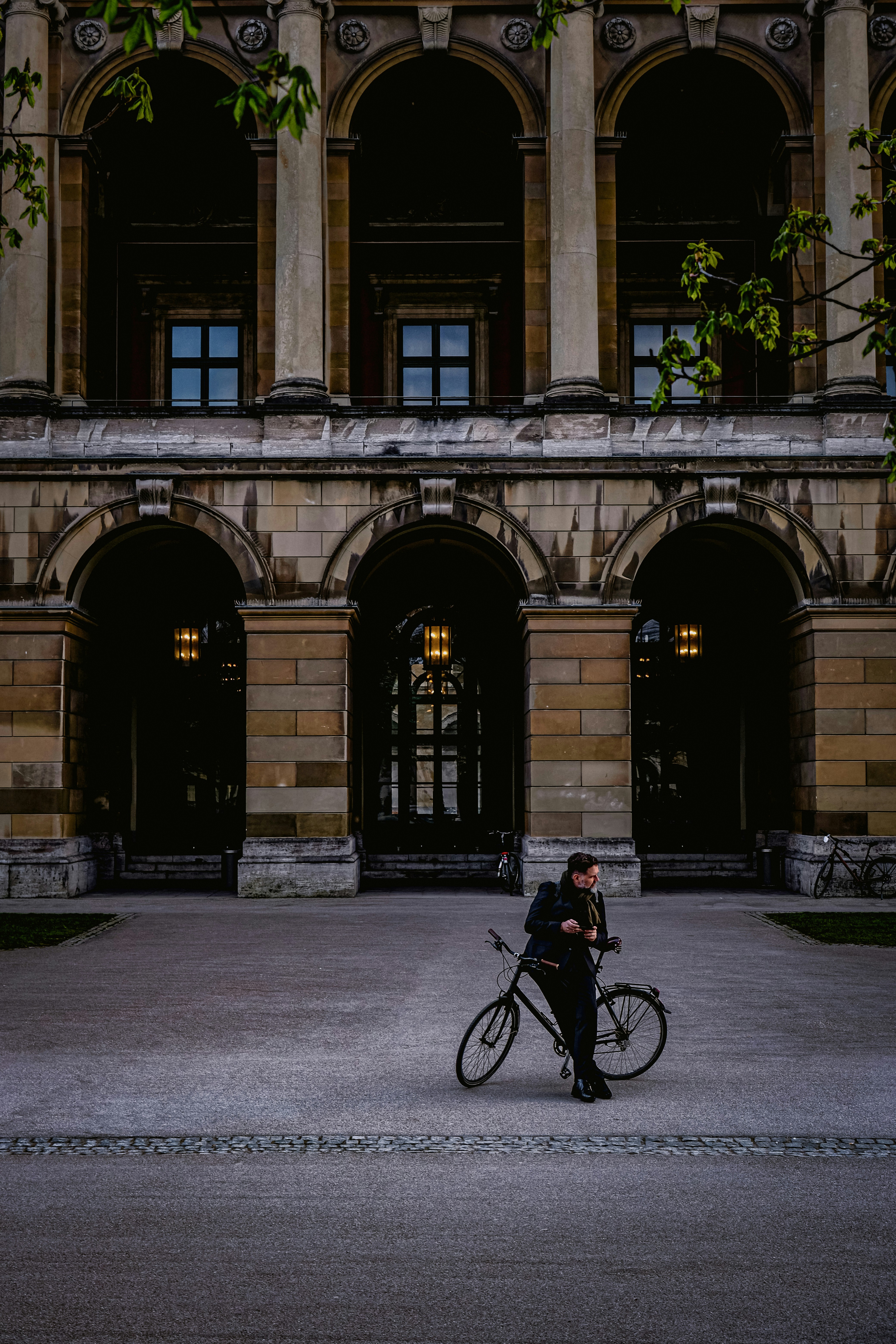 Cyclist in Shadowed Courtyard Beneath Historic Arches