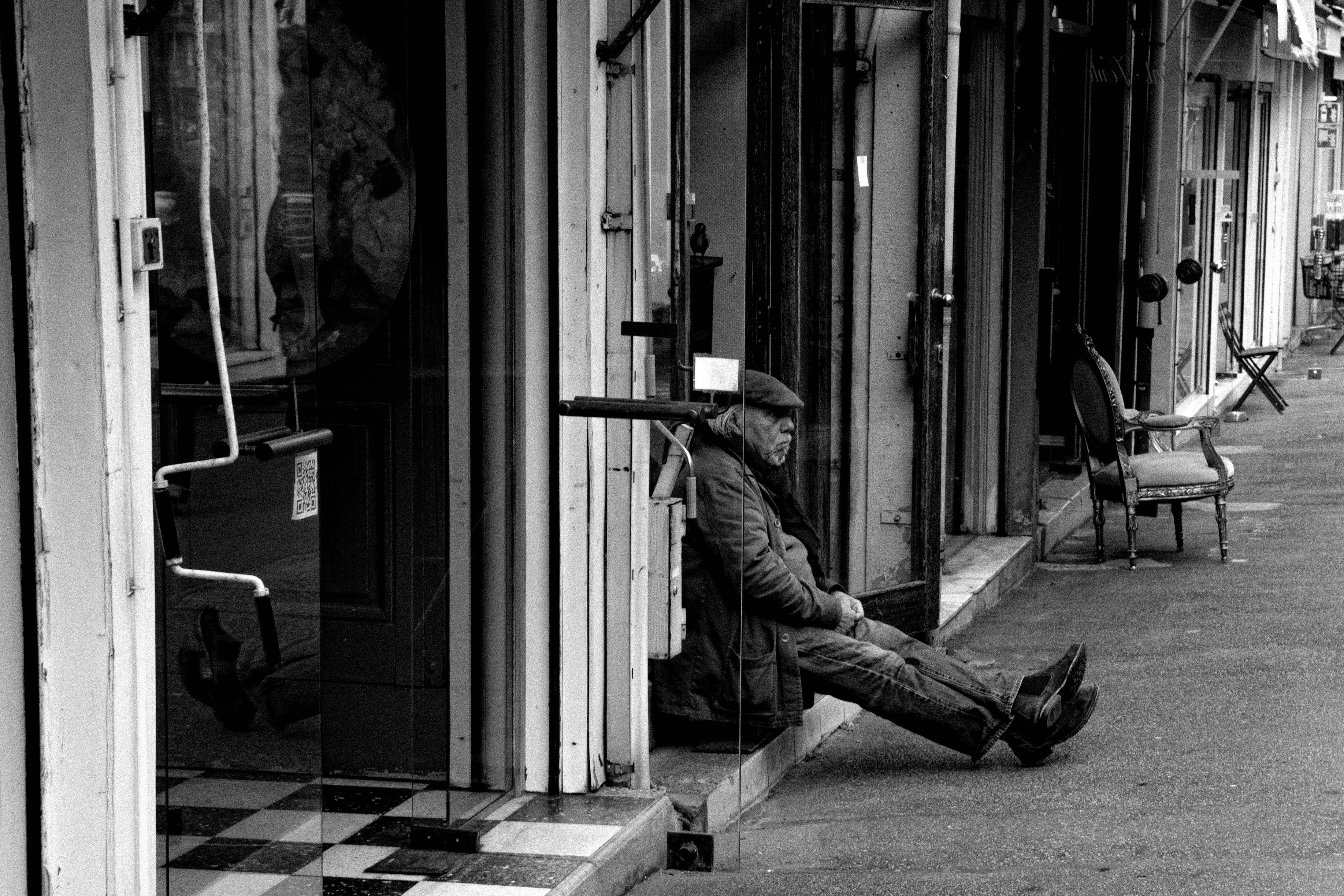 Lonely Shopfront: A Seated Stranger in Quiet Urban Dusk