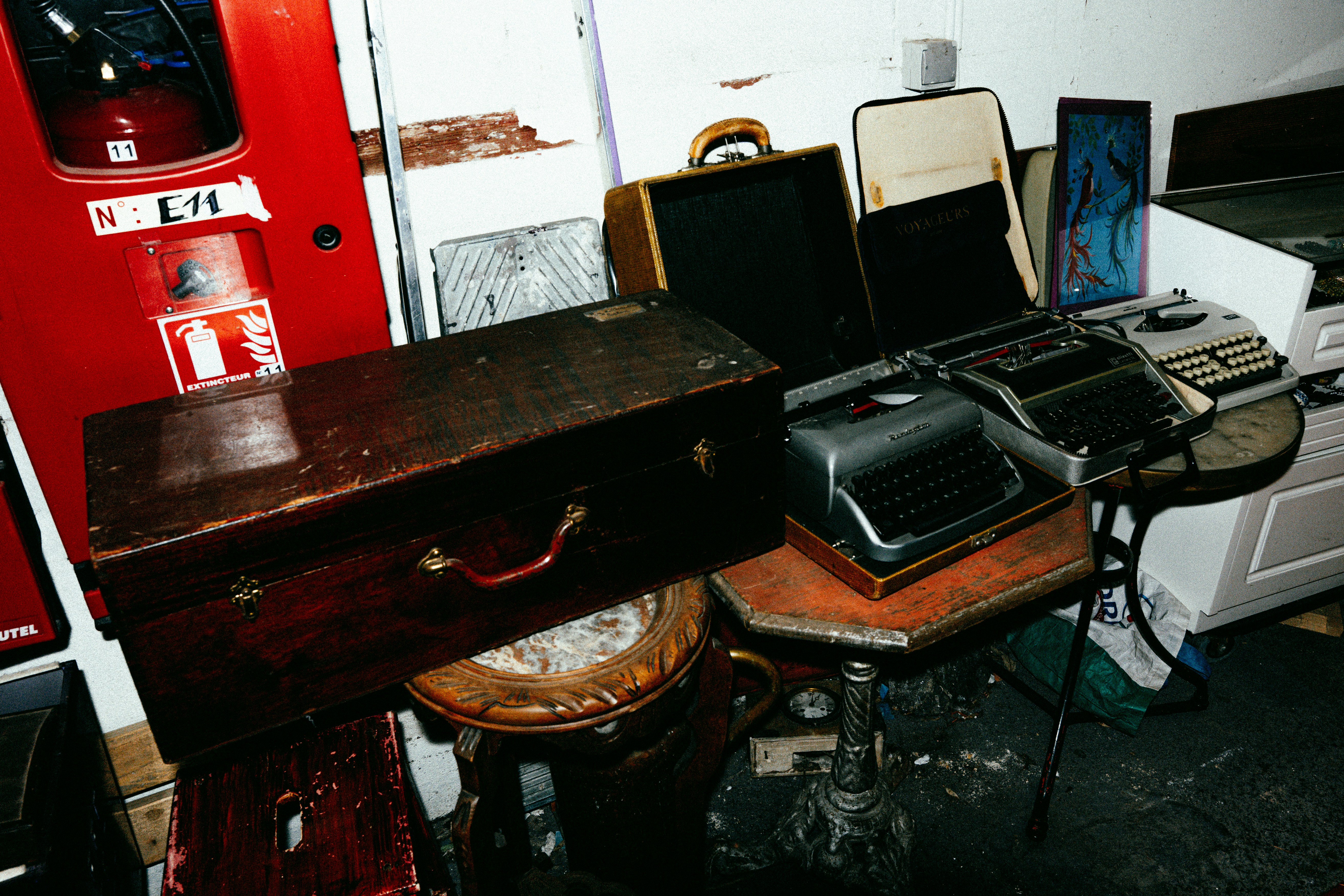 Dusty Office Relic: Vintage Typewriters and a Red Locker in a Faded Studio