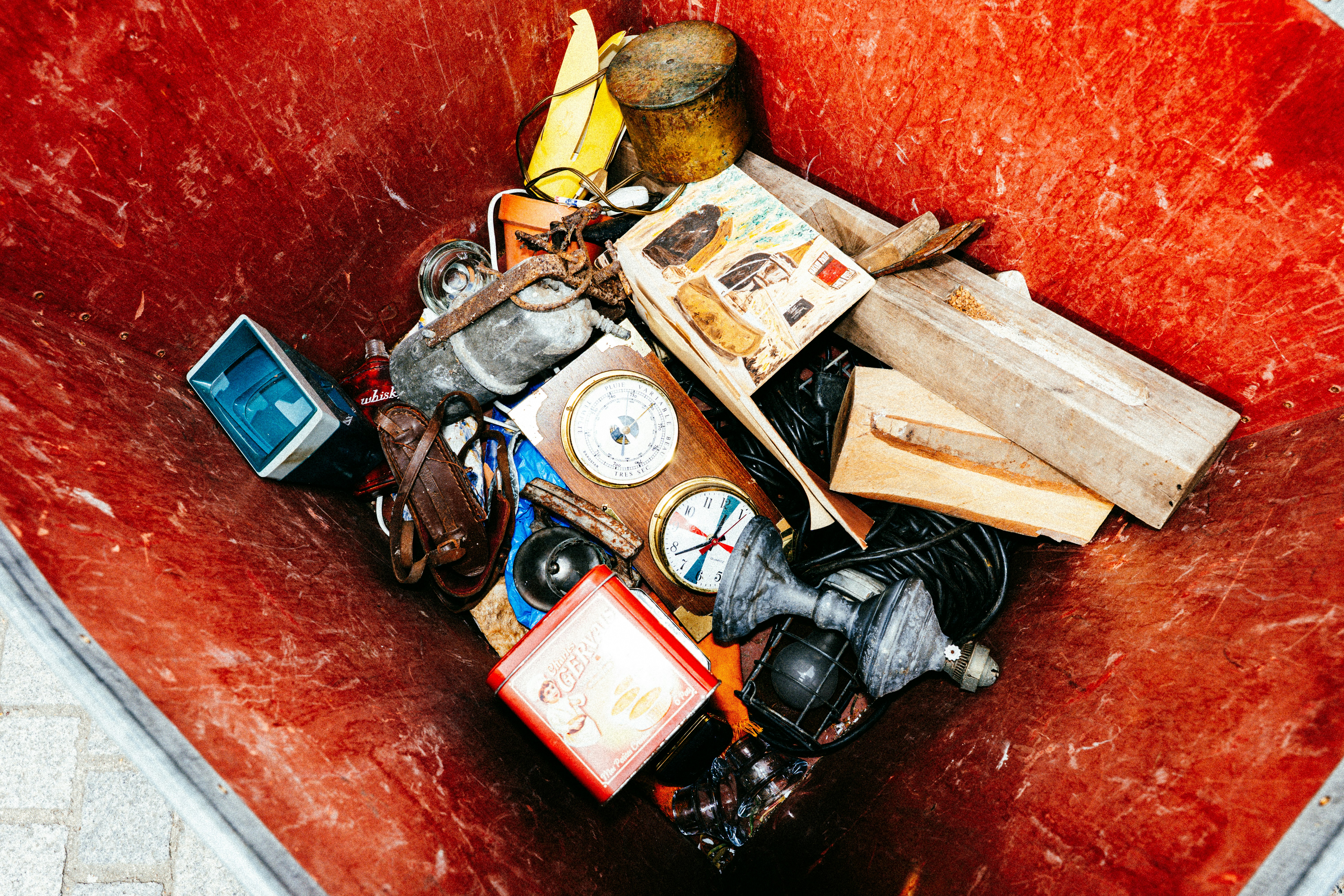 Trash Heap Treasure: A Colorful Stack of Odds and Ends in a Red Dumpster