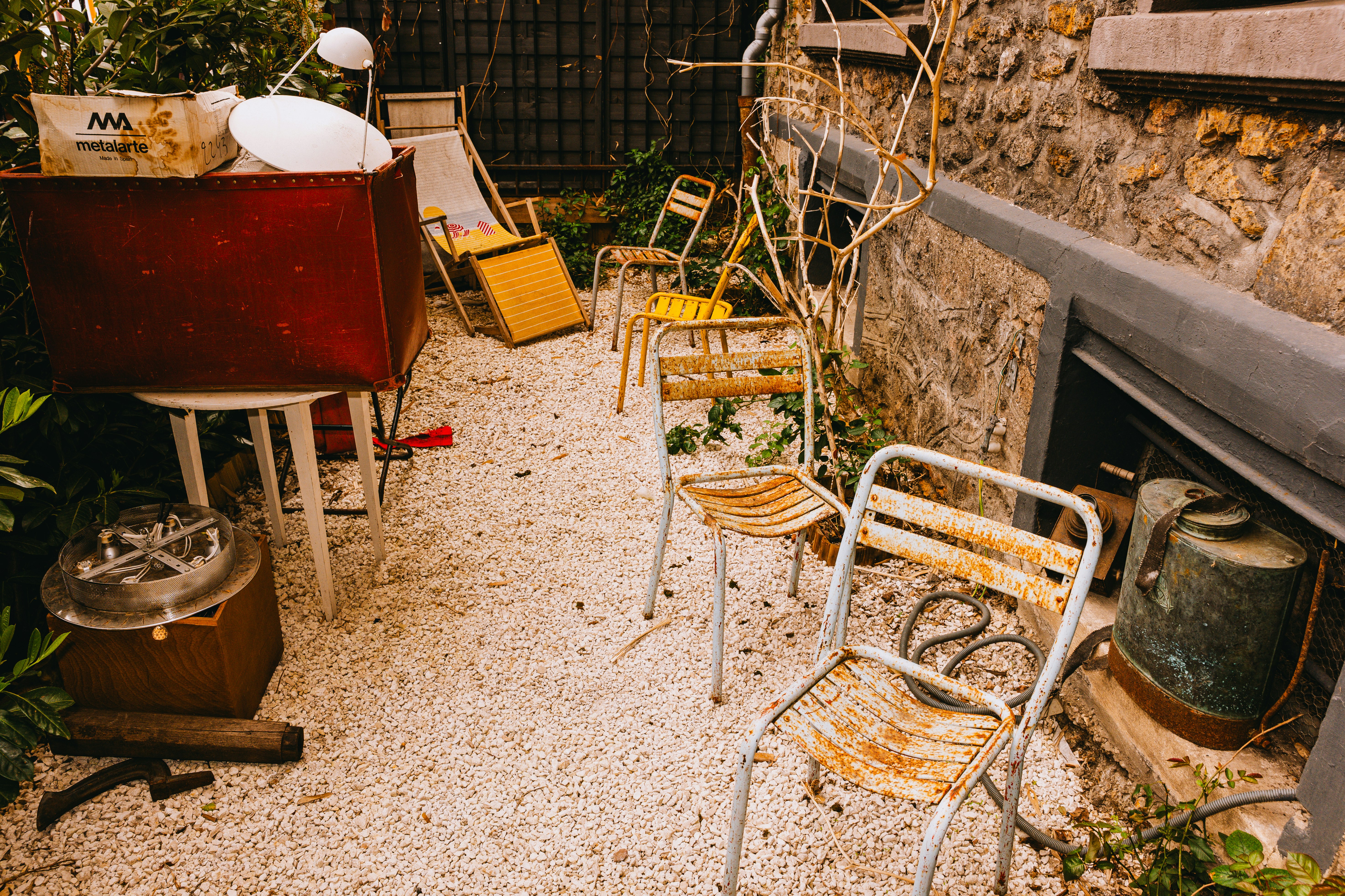 Rust and Gravel: an Abandoned Courtyard Arranged with Weathered Chairs