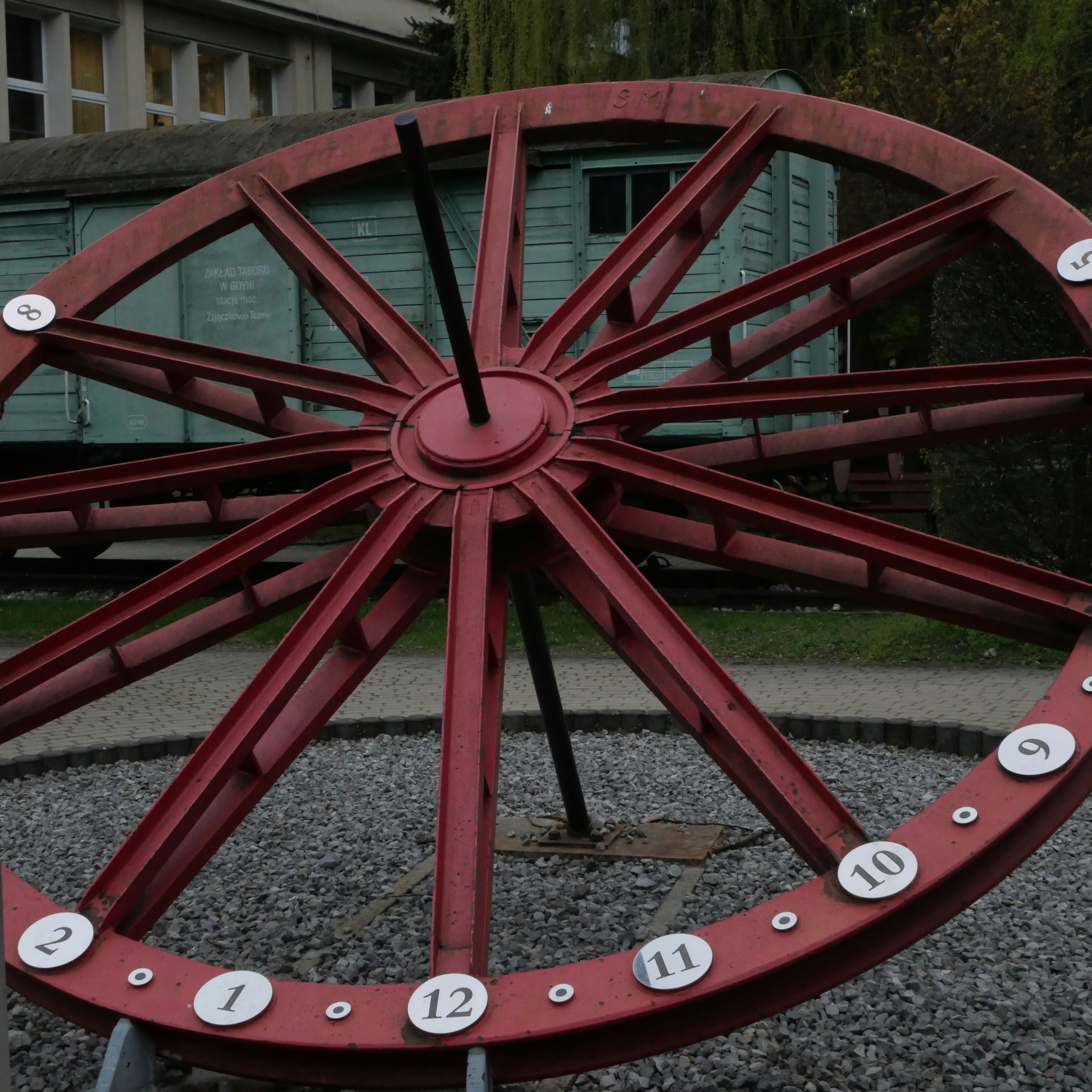 Symmetry in Red: A Wheel's Radiating Framework Framed Against Quiet Grounds