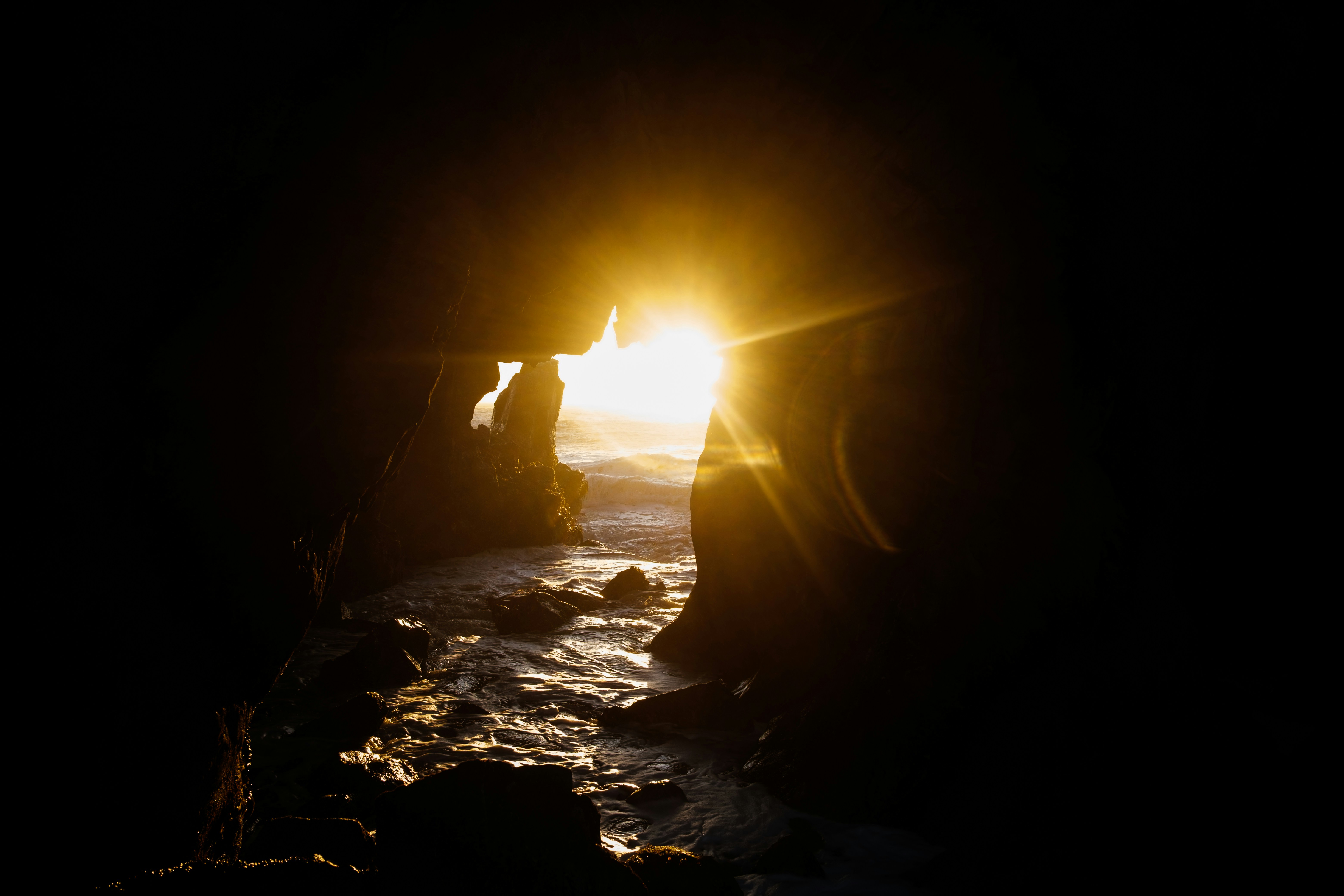 Sunlit Portal: A Cave’s Narrow Exit to the Sea