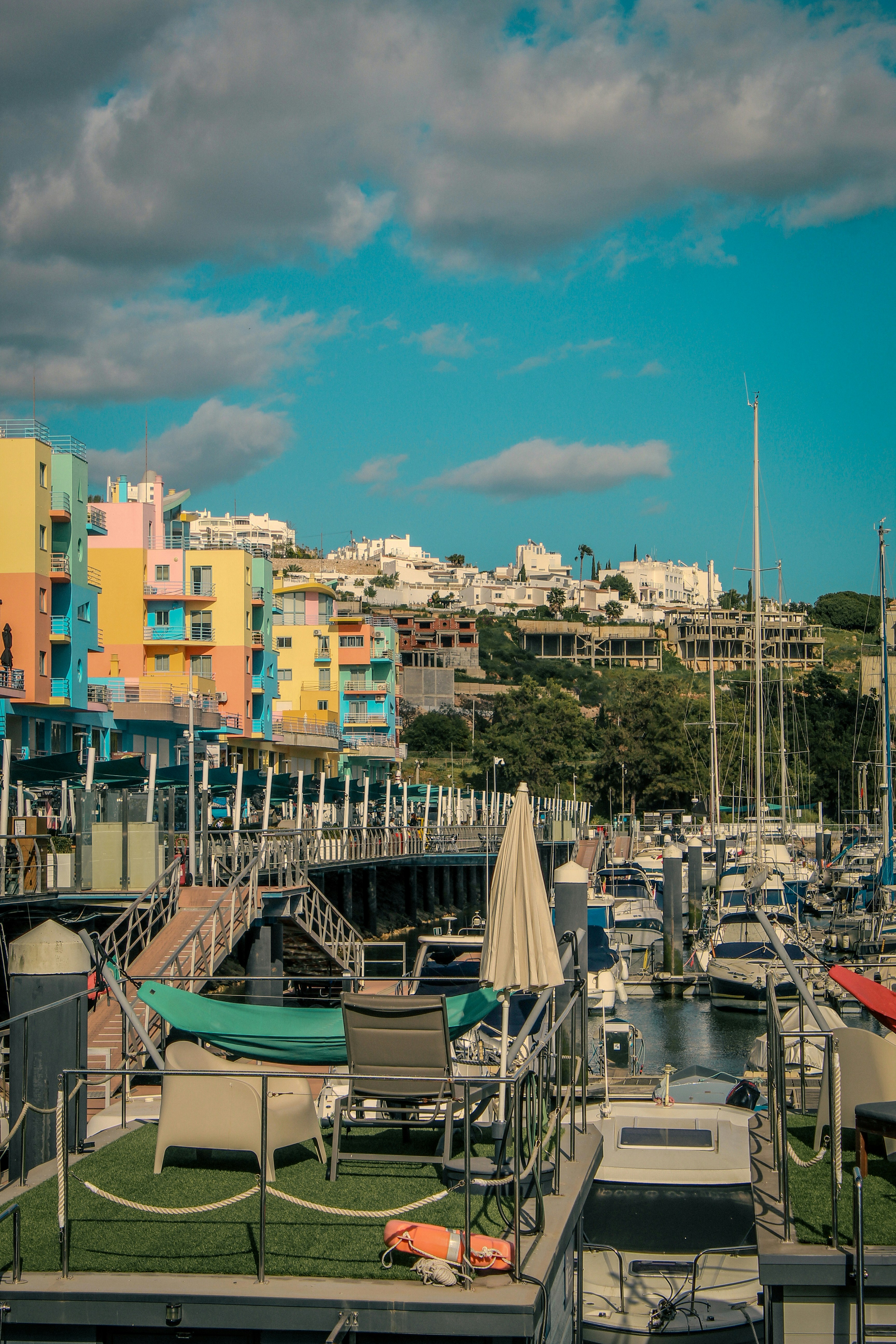 Colorful Harbor Village: Boats, Decks, and Hulls Under a Blue Sky