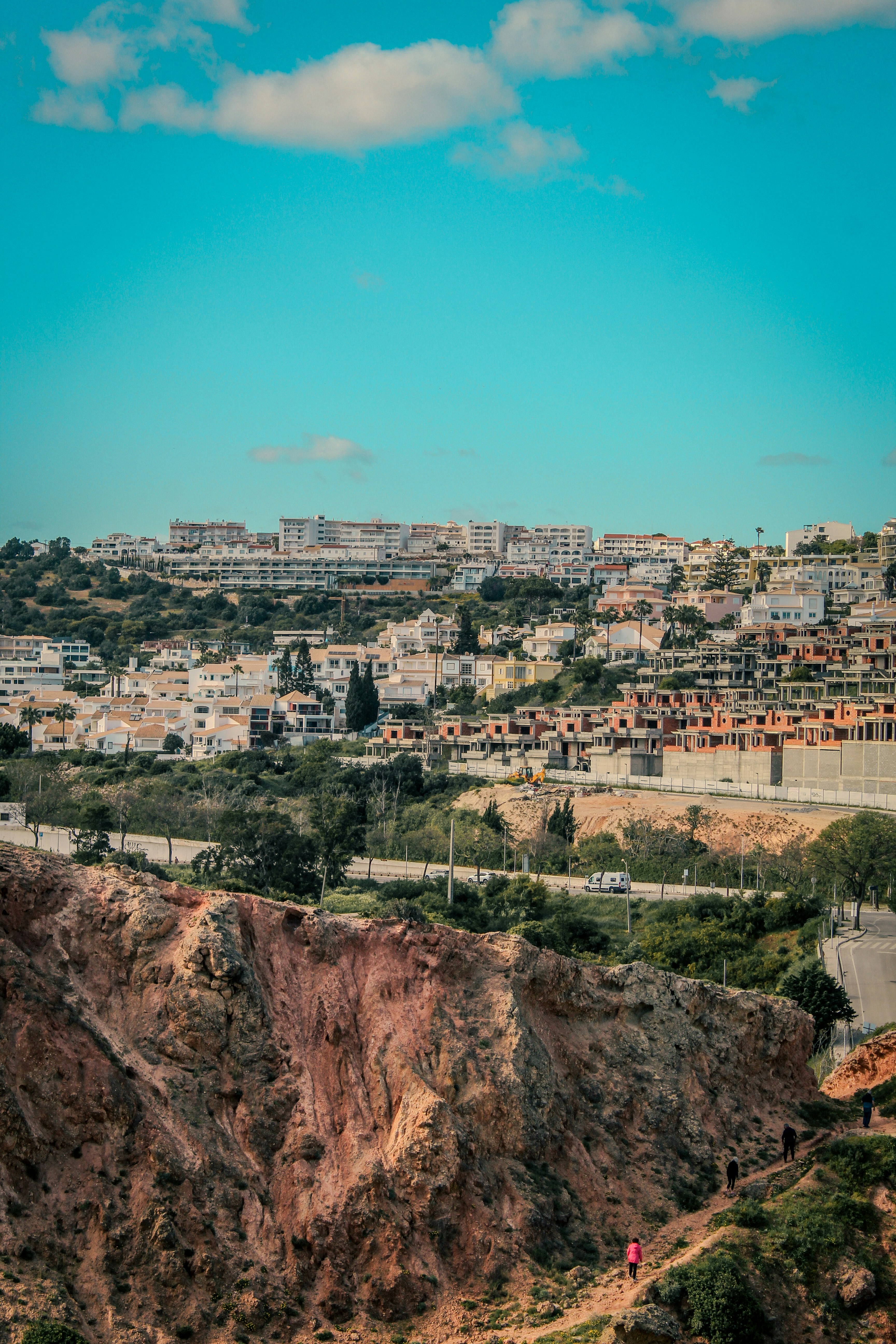 Clifftop overlook: coastal town tucked along red rock and winding road