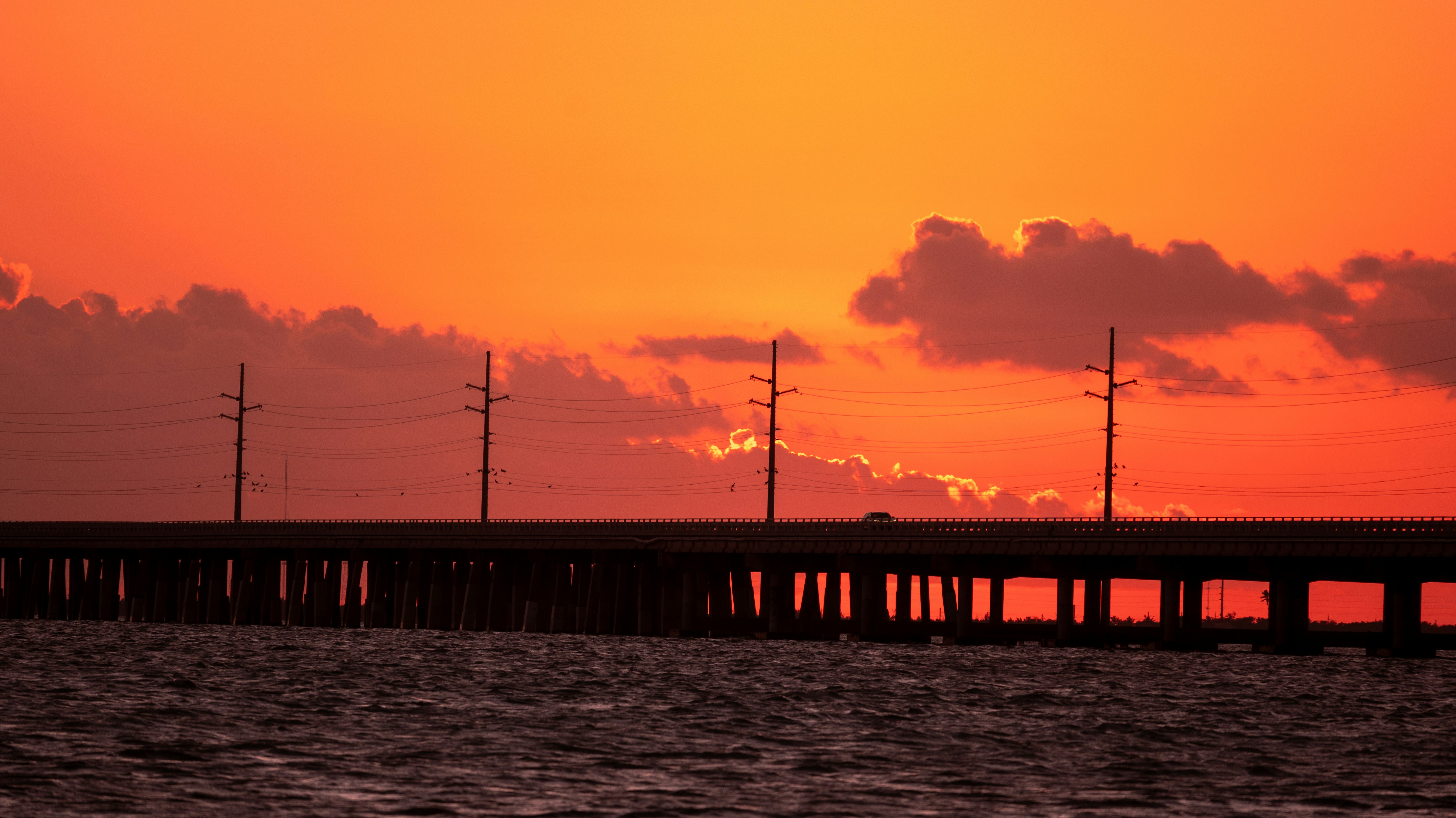 Sunset Pier: Silhouettes and Rails Over Quiet Waves