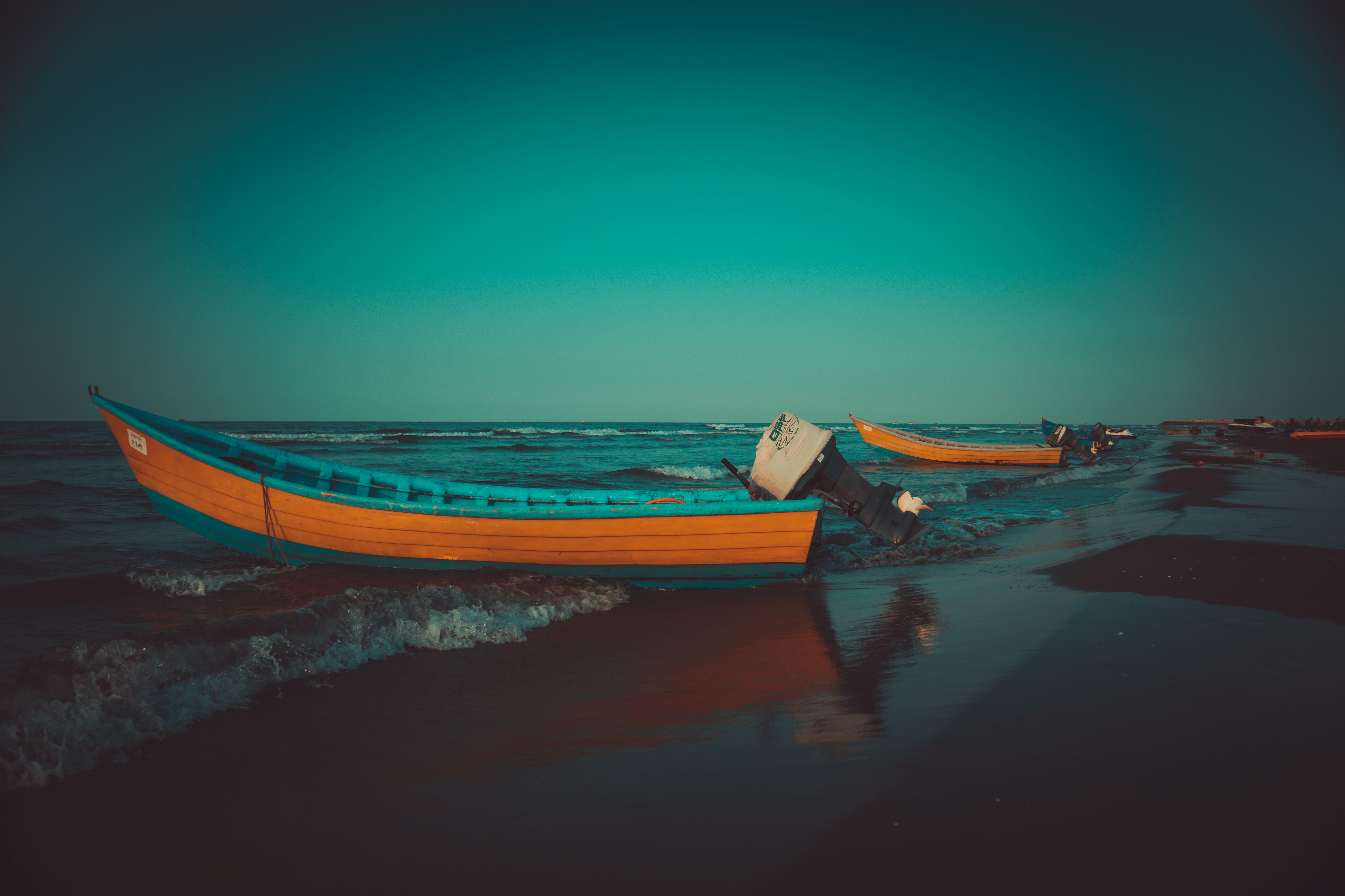 Golden Boats Rest at Dusk: Quiet Blues and Surf on a Shore