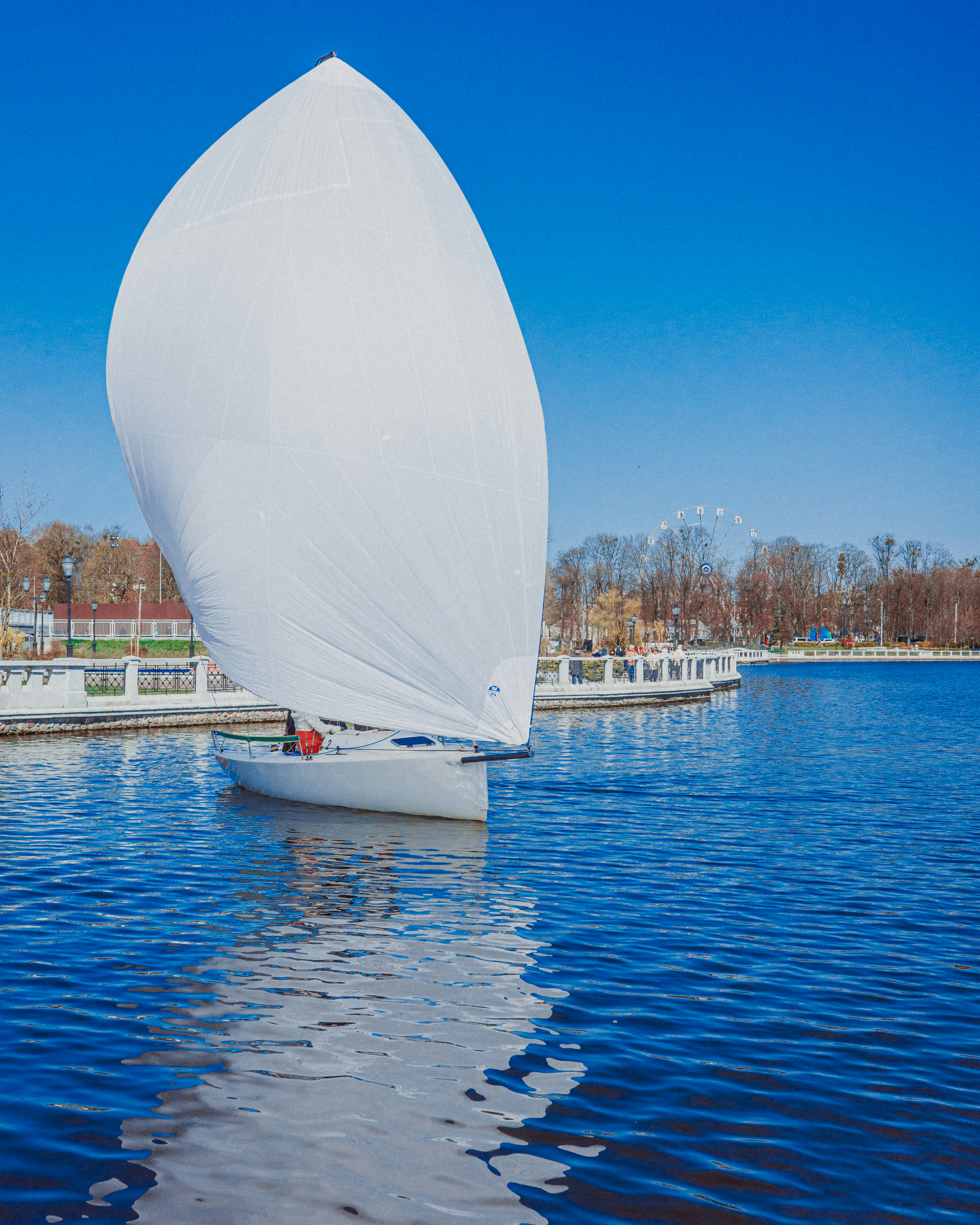 White Sail on Quiet Blue: A Vessel at Rest by the Pier