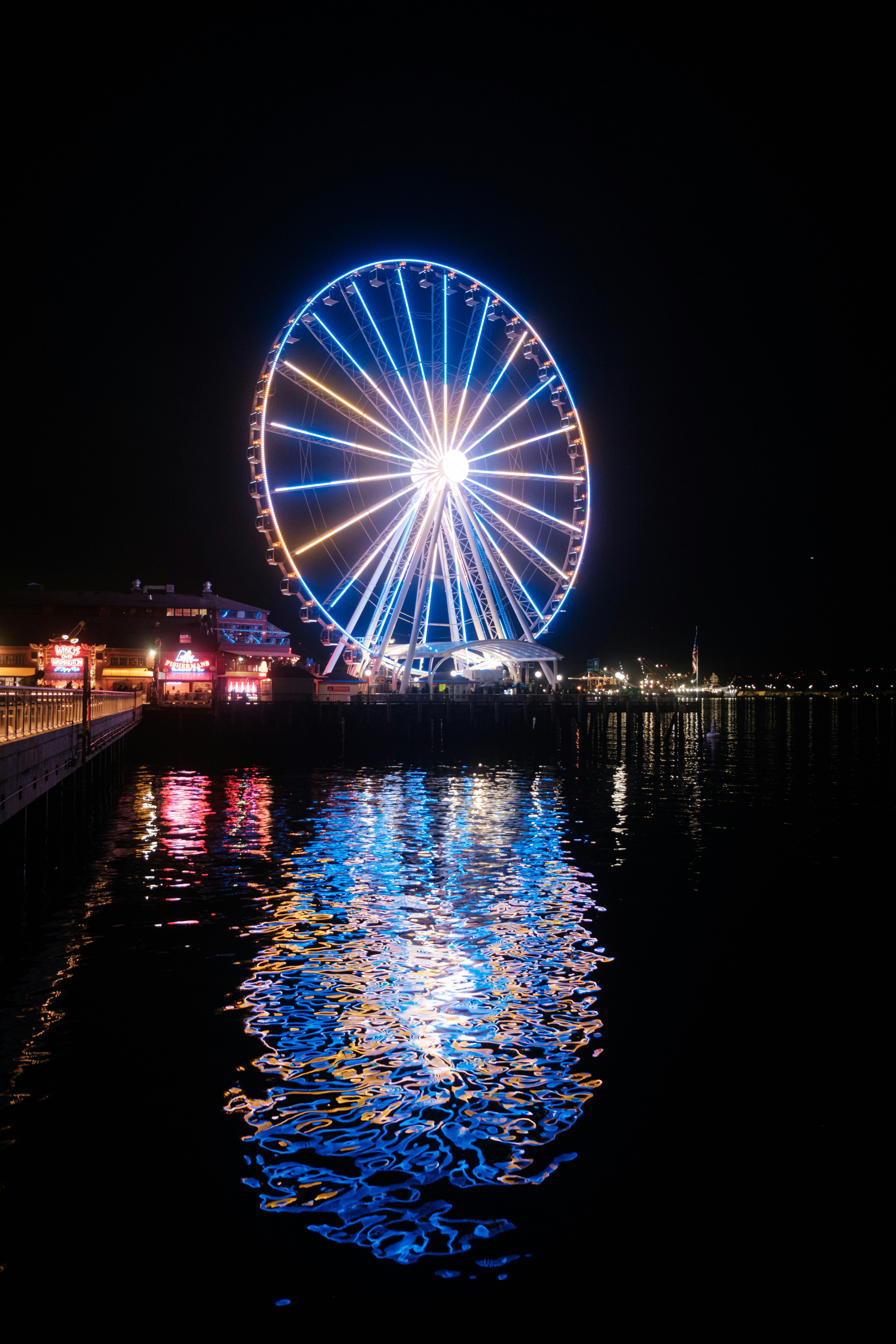 Neon Wheel over Water: Nighttime Pier at the Boardwalk
