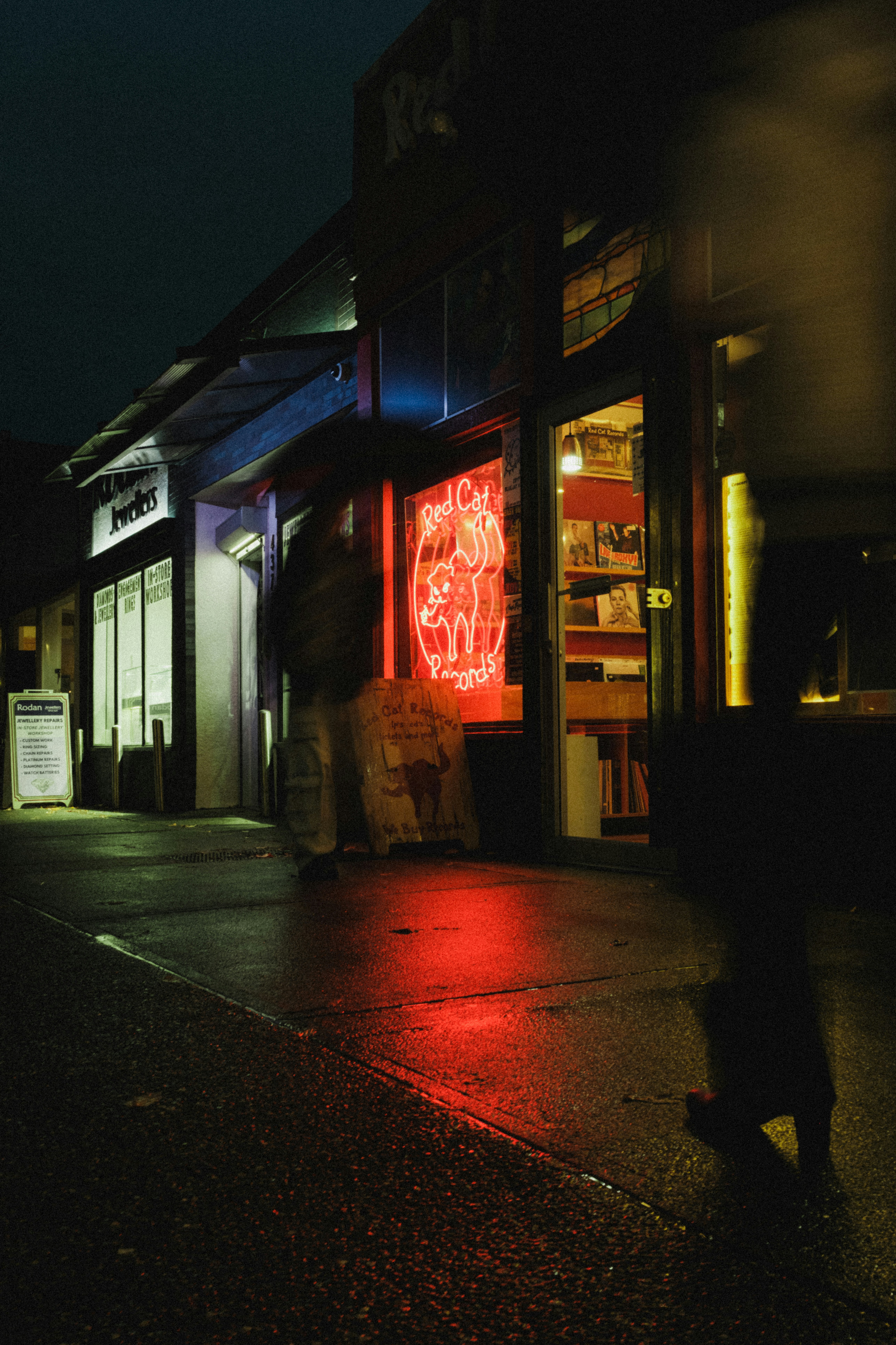 Red Neon Alley: Quiet Figures and City Light Reflections