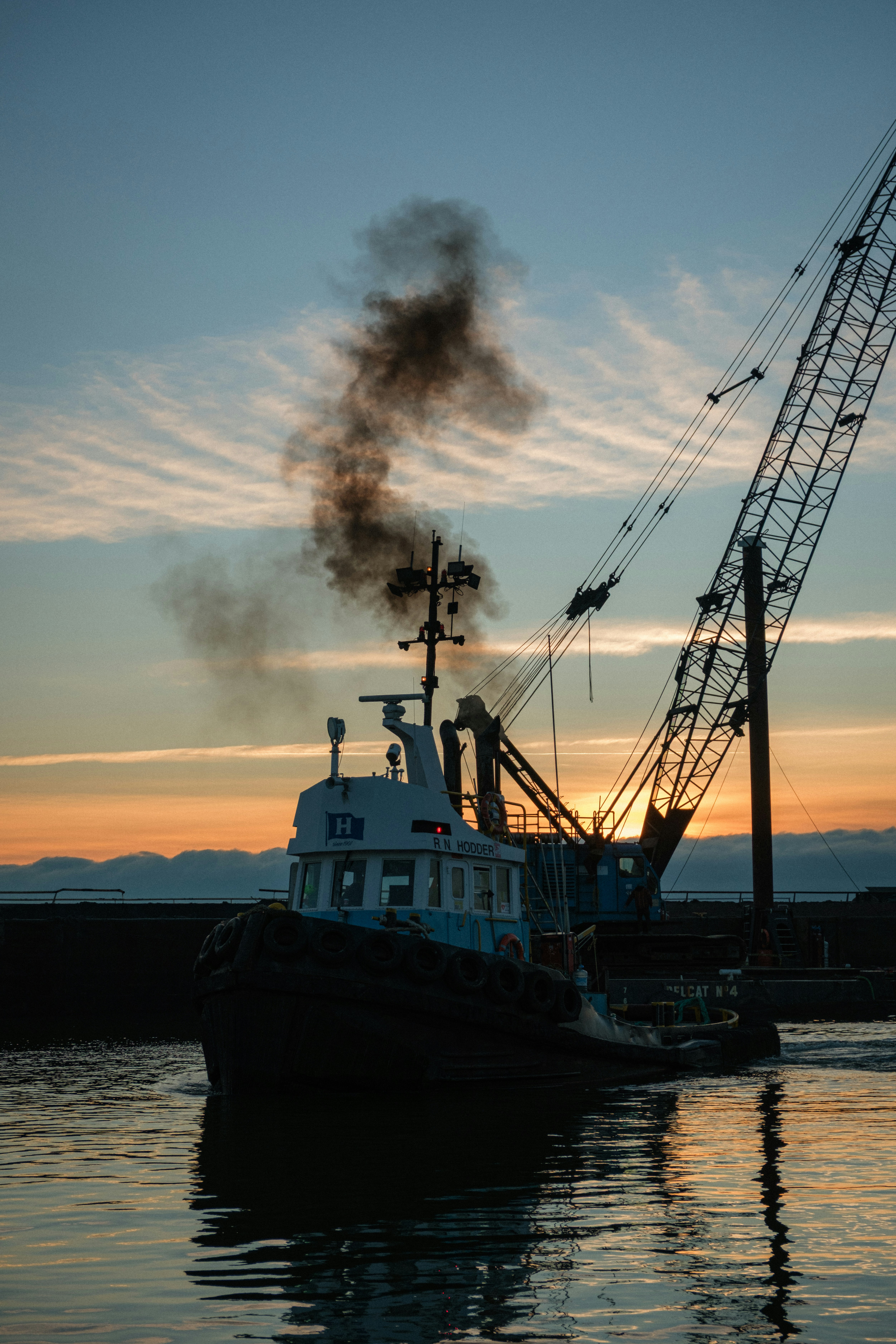 Smoke and Crane at Sunset: A Tug's Quiet Power