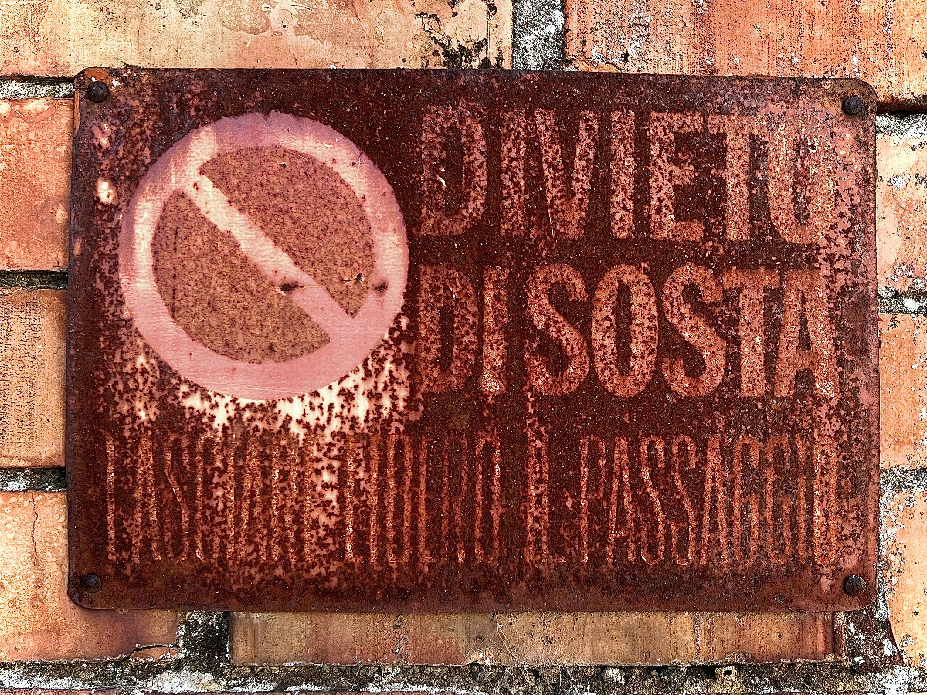 Rusted No Entry: A Weathered Warning Plate on Brick