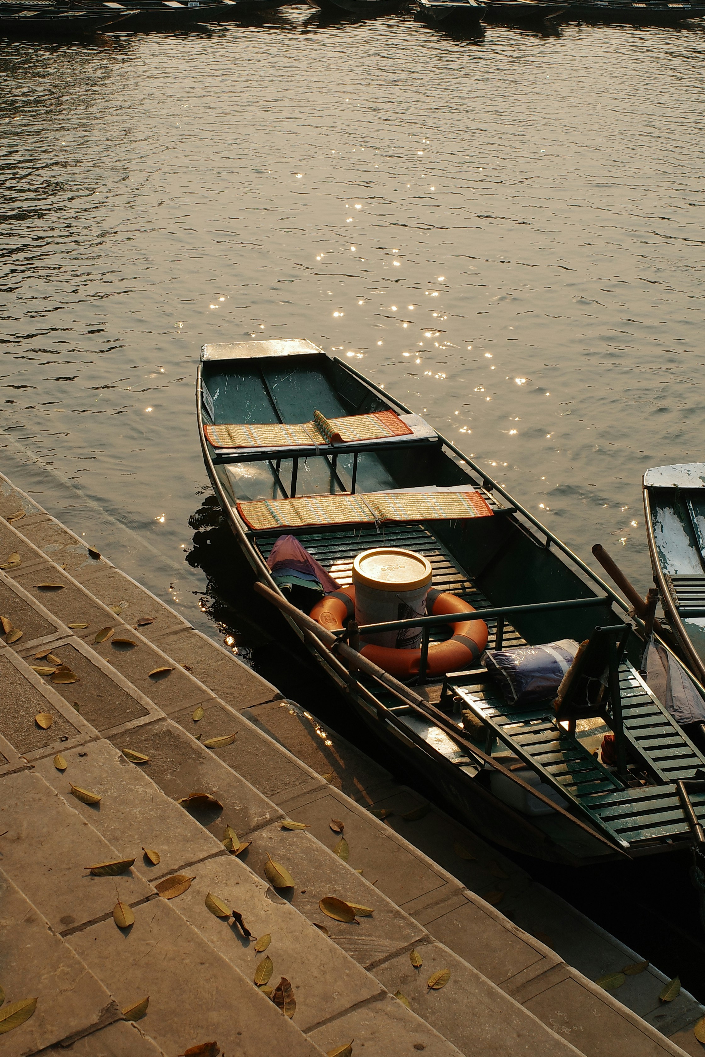 Docked Boats on Sunlit River: A Quiet Morning by the Steps