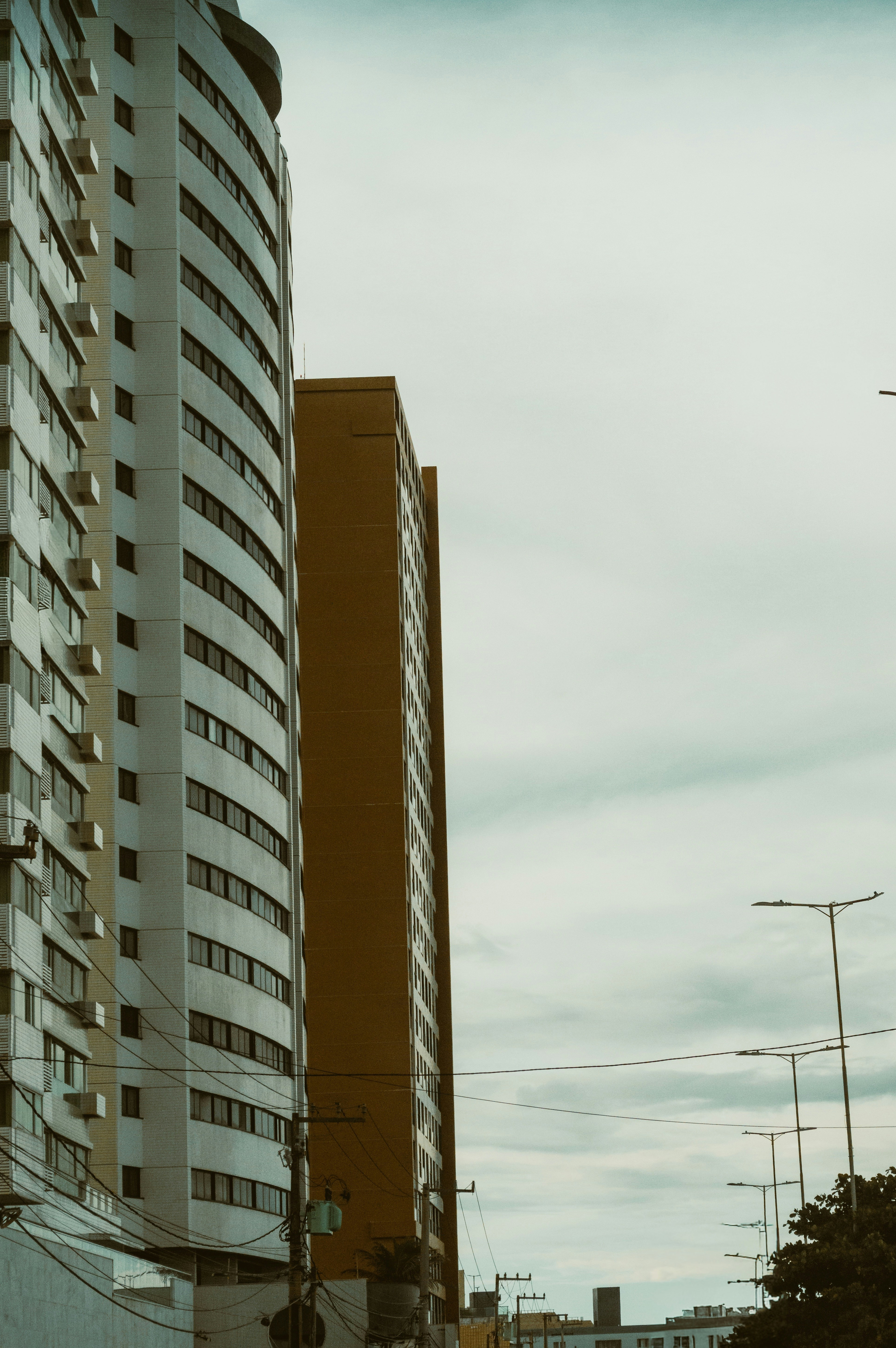 Vertical Cityscape: A Narrow Tower Juts Against a Pale Sky