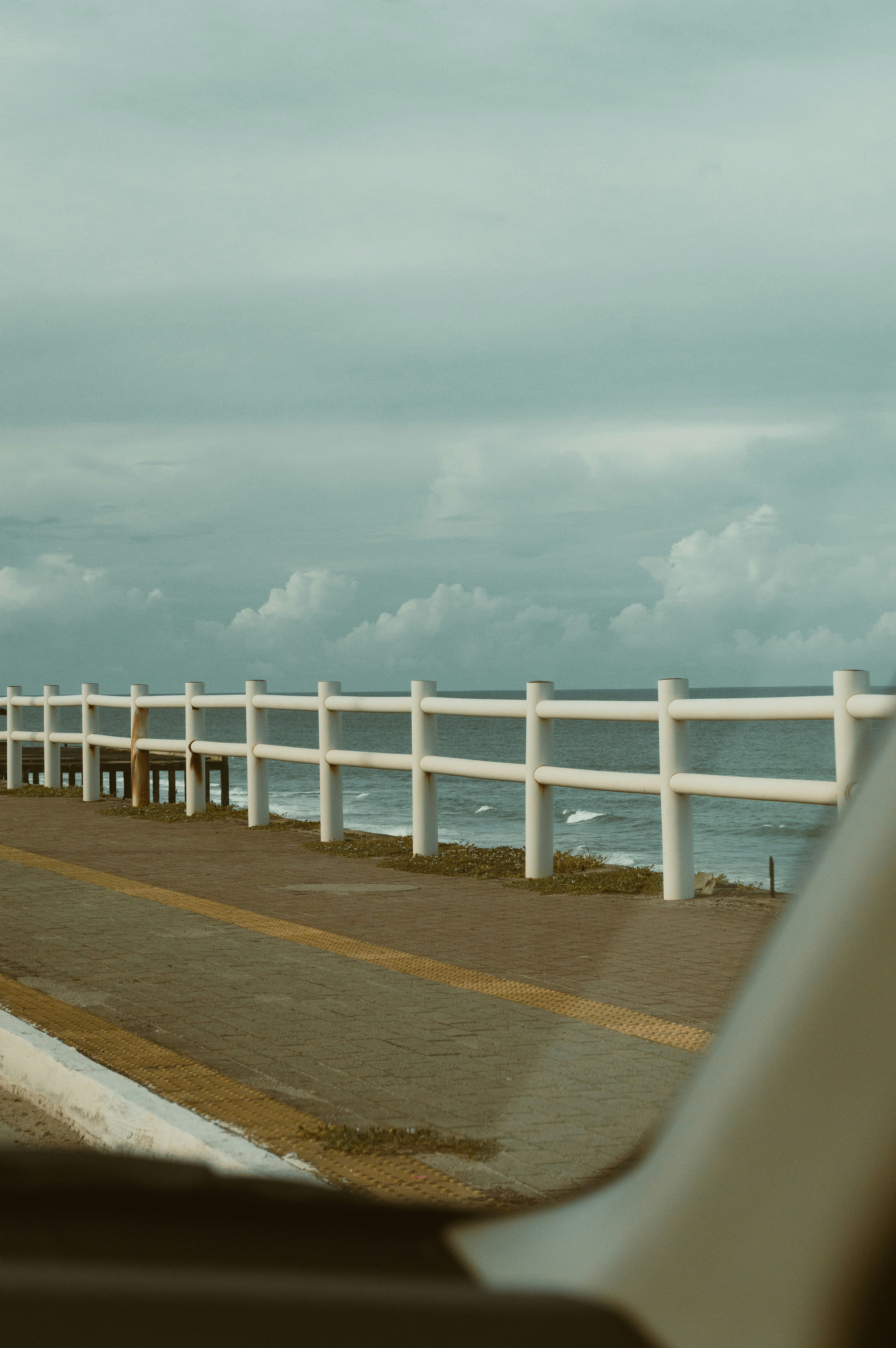 Seaside Rail and Horizon: A Quiet Drive-by Moment