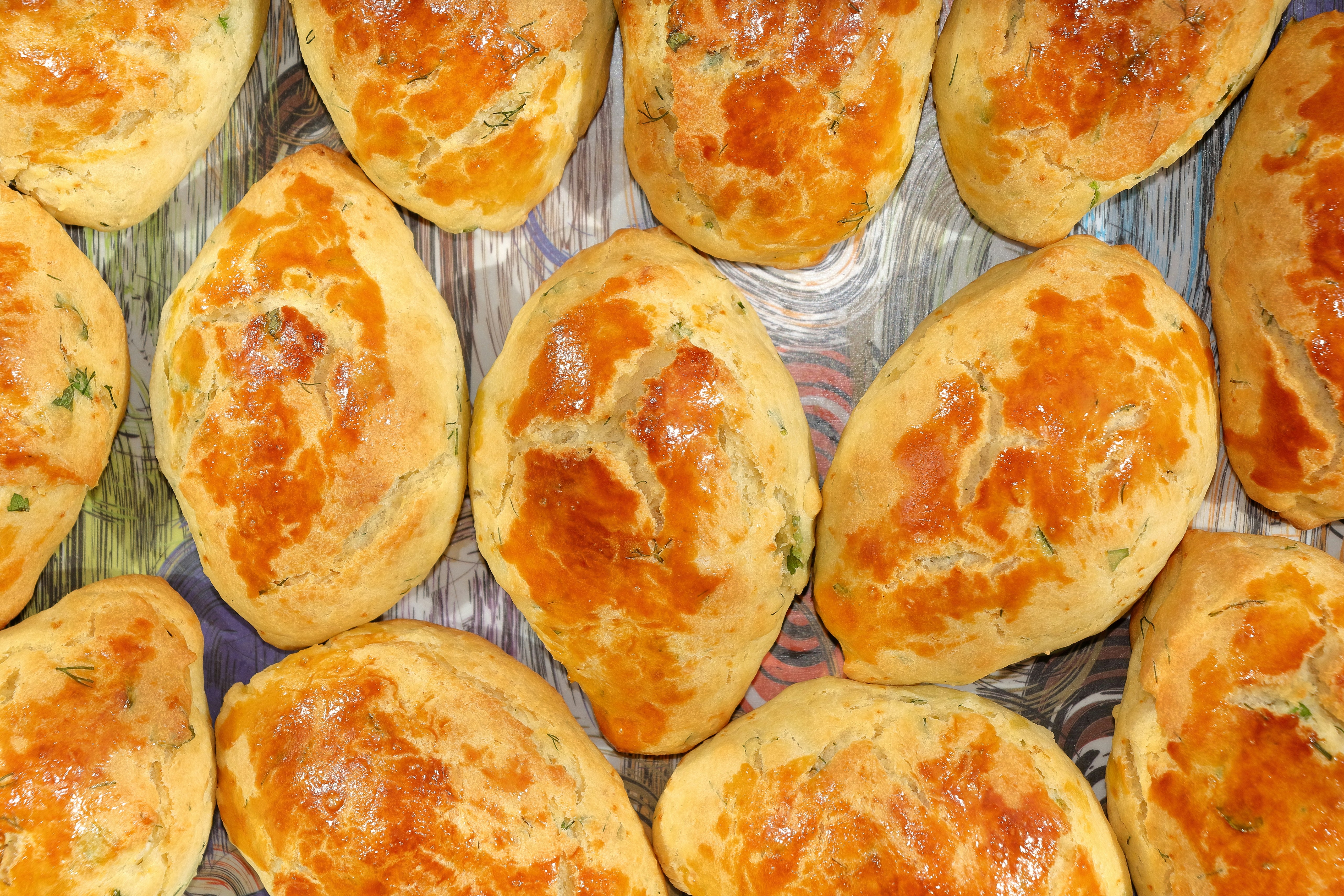 Golden-Brown Pastry Buns Aligned Across a Rustic Tray
