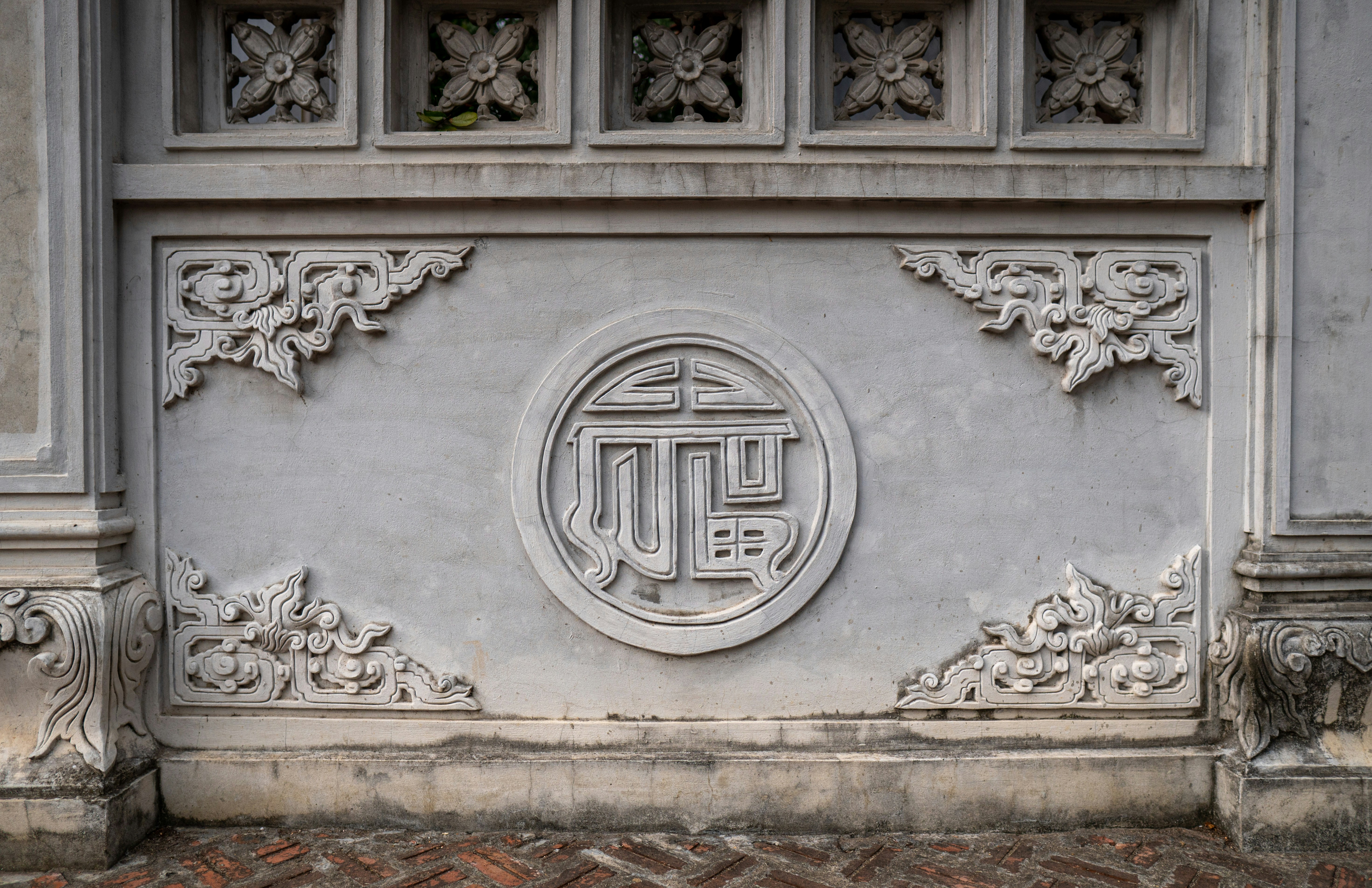 Carved Marble Emblem Centered between Ornate Reliefs