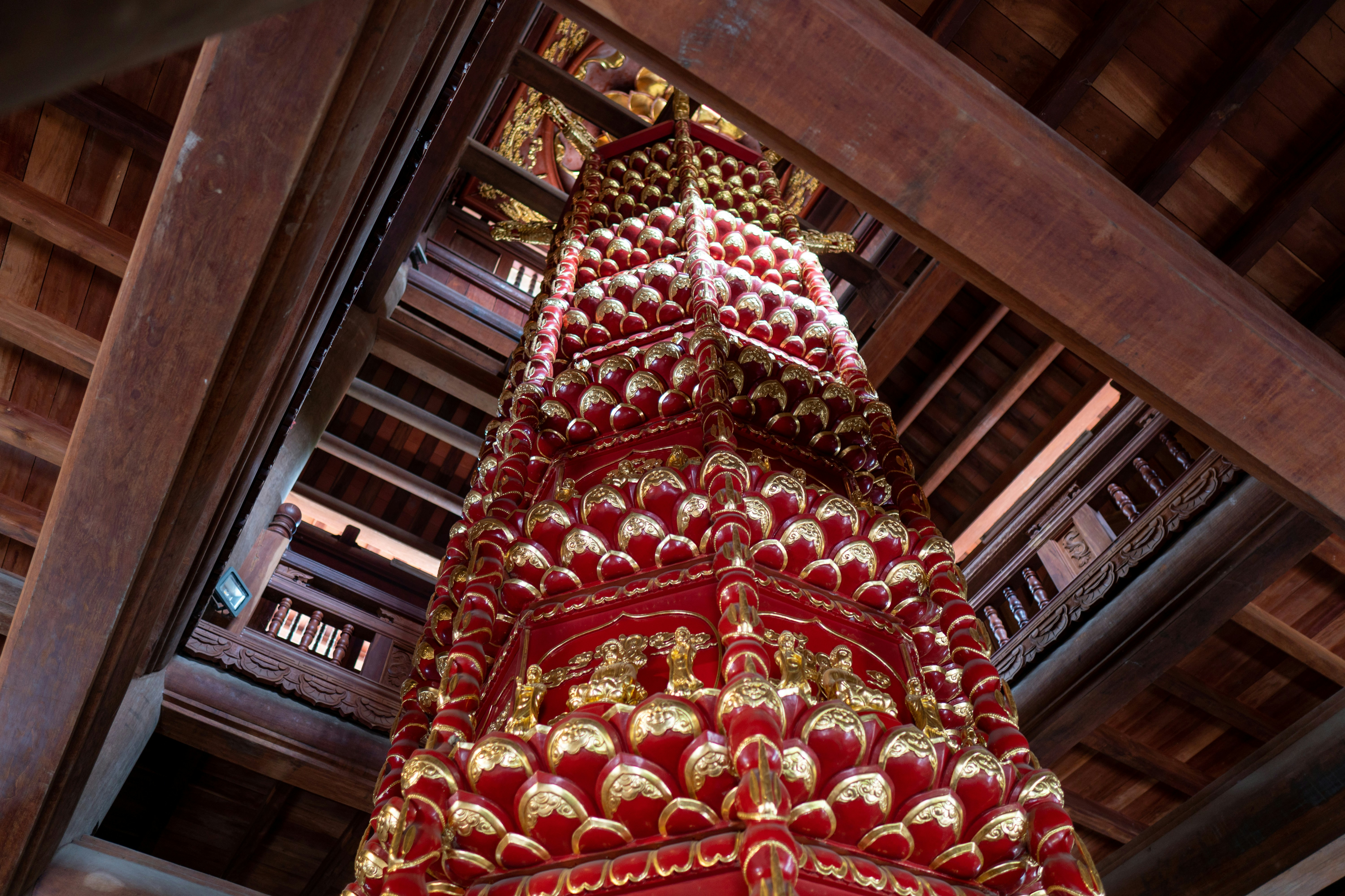 Cascade of Crimson Ornaments: A Towering Red Structure in Sacred Wood