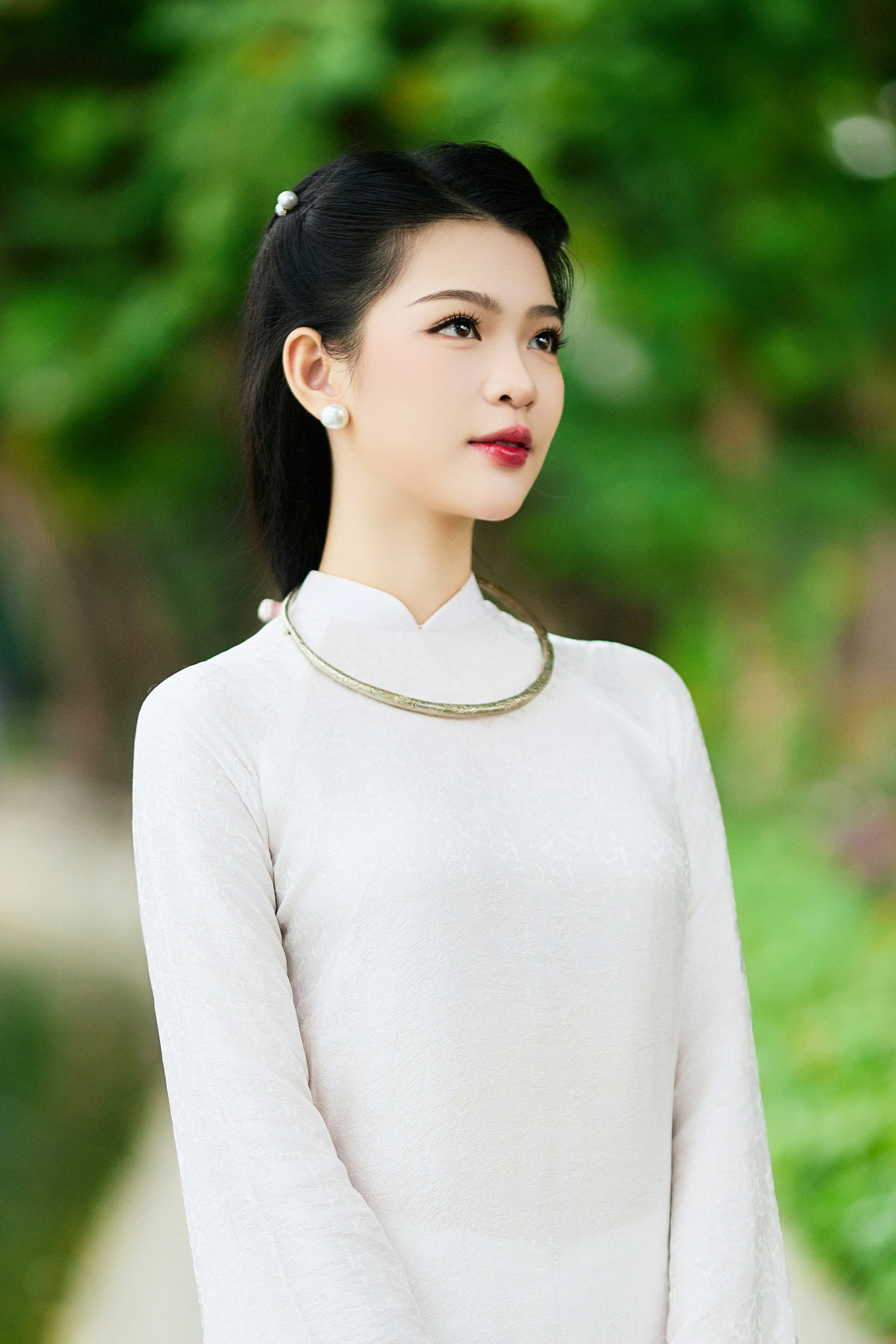 Grace in White: Soft Focus Portrait Beneath Verdant Canopy