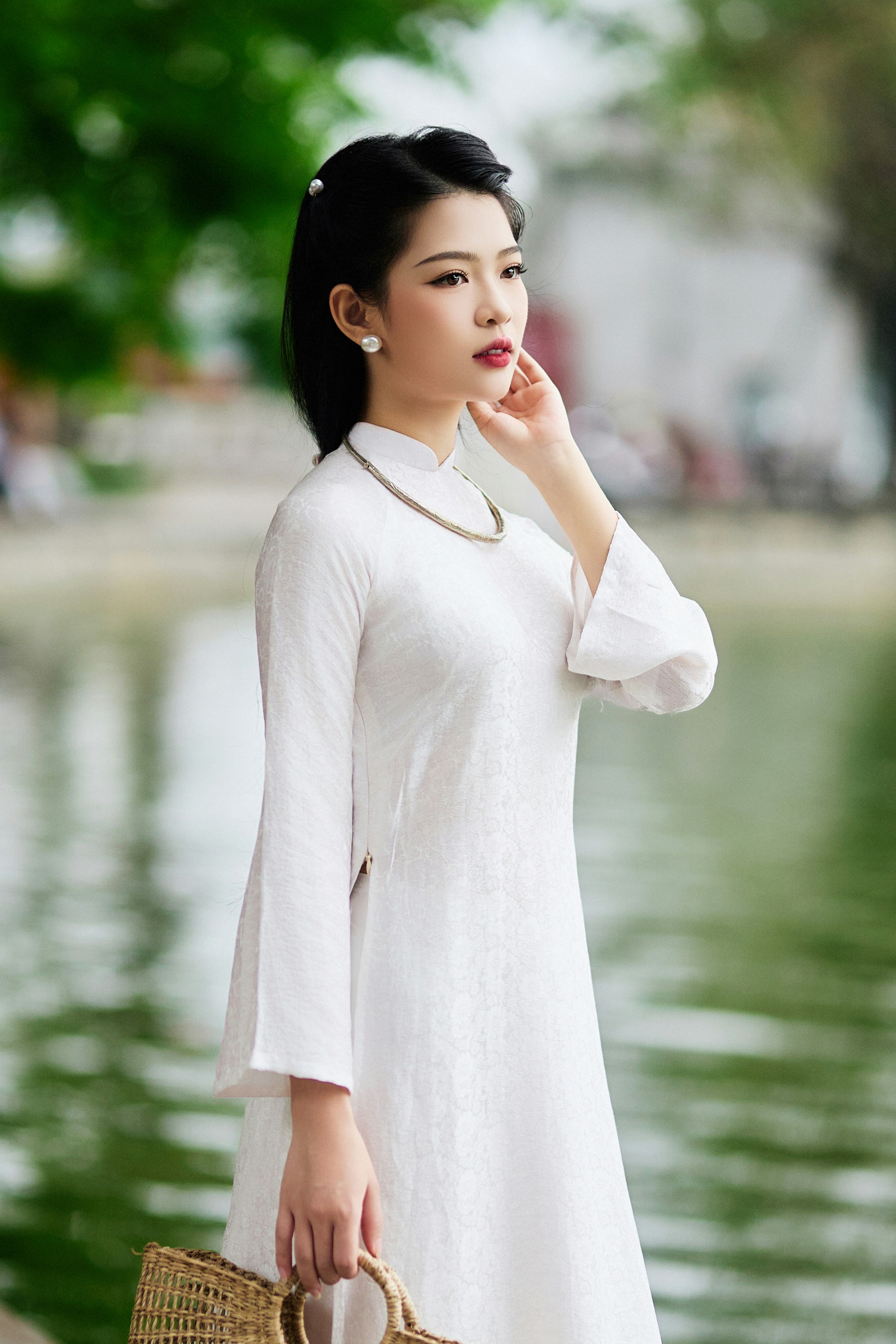 Grace in White: Poised Contemplation by the Water