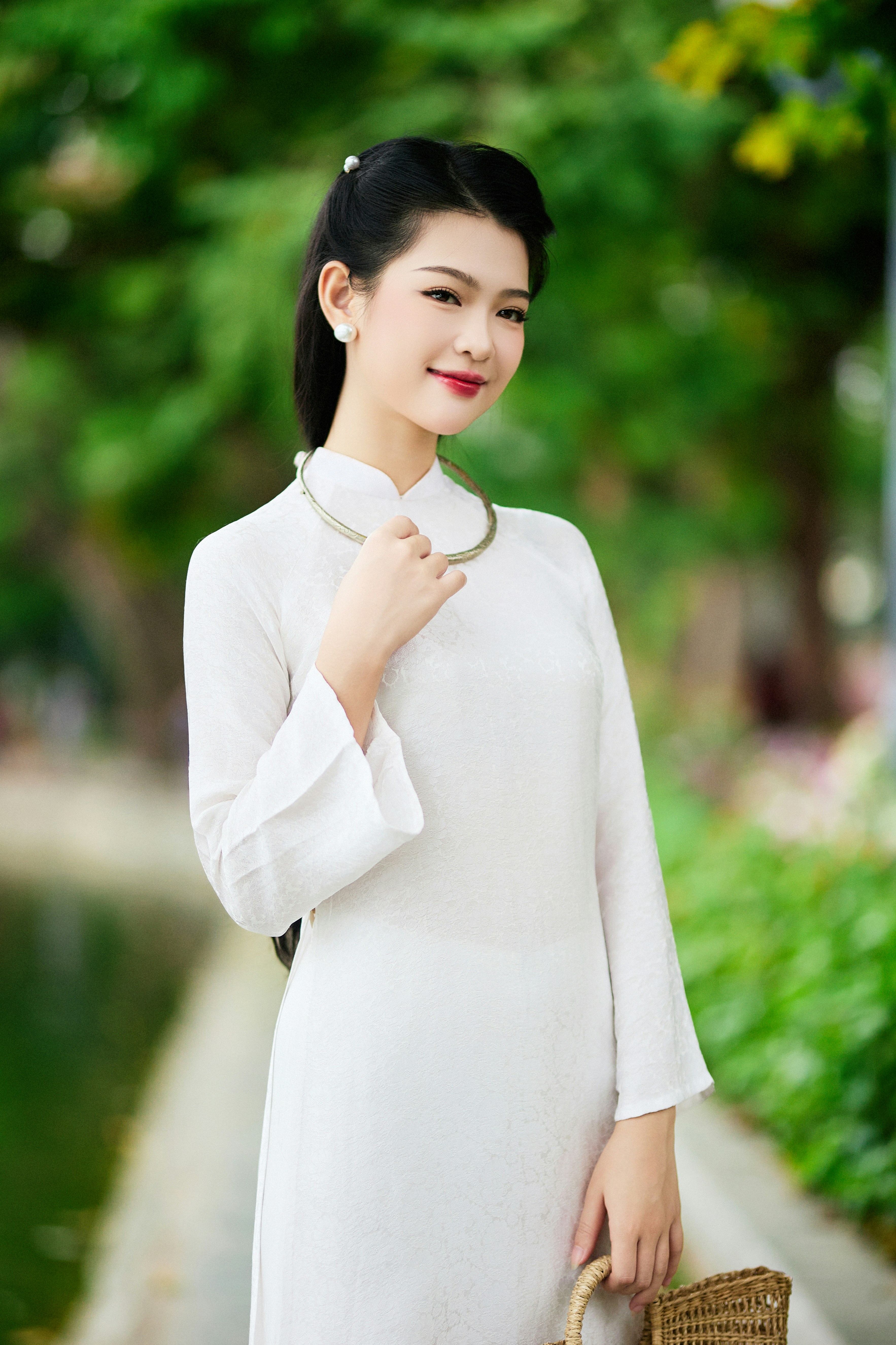Graceful Poise in White: Portrait of Elegance Under Garden Light