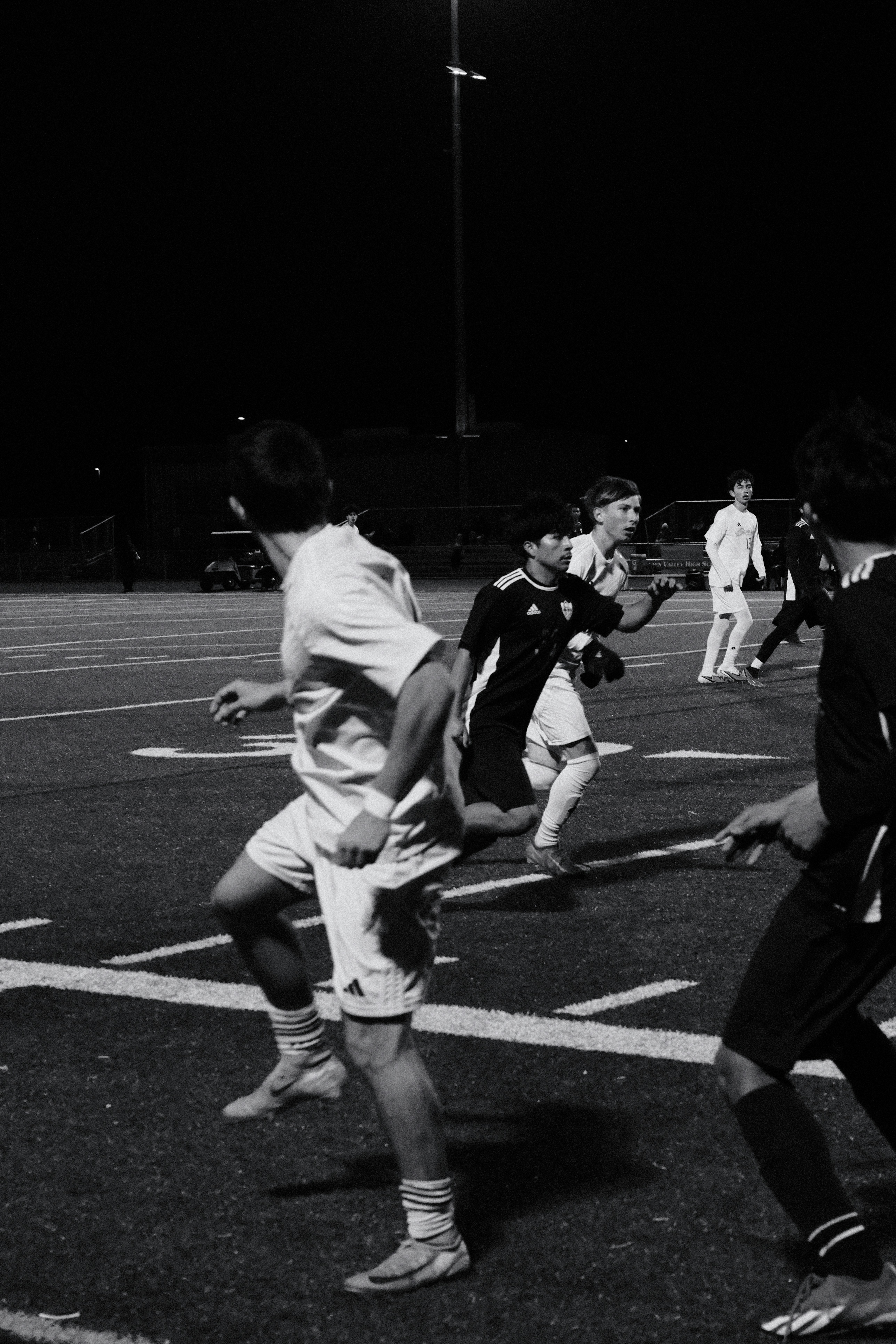 Midfield Rush: Black-and-White Night Soccer on a Floodlit Field
