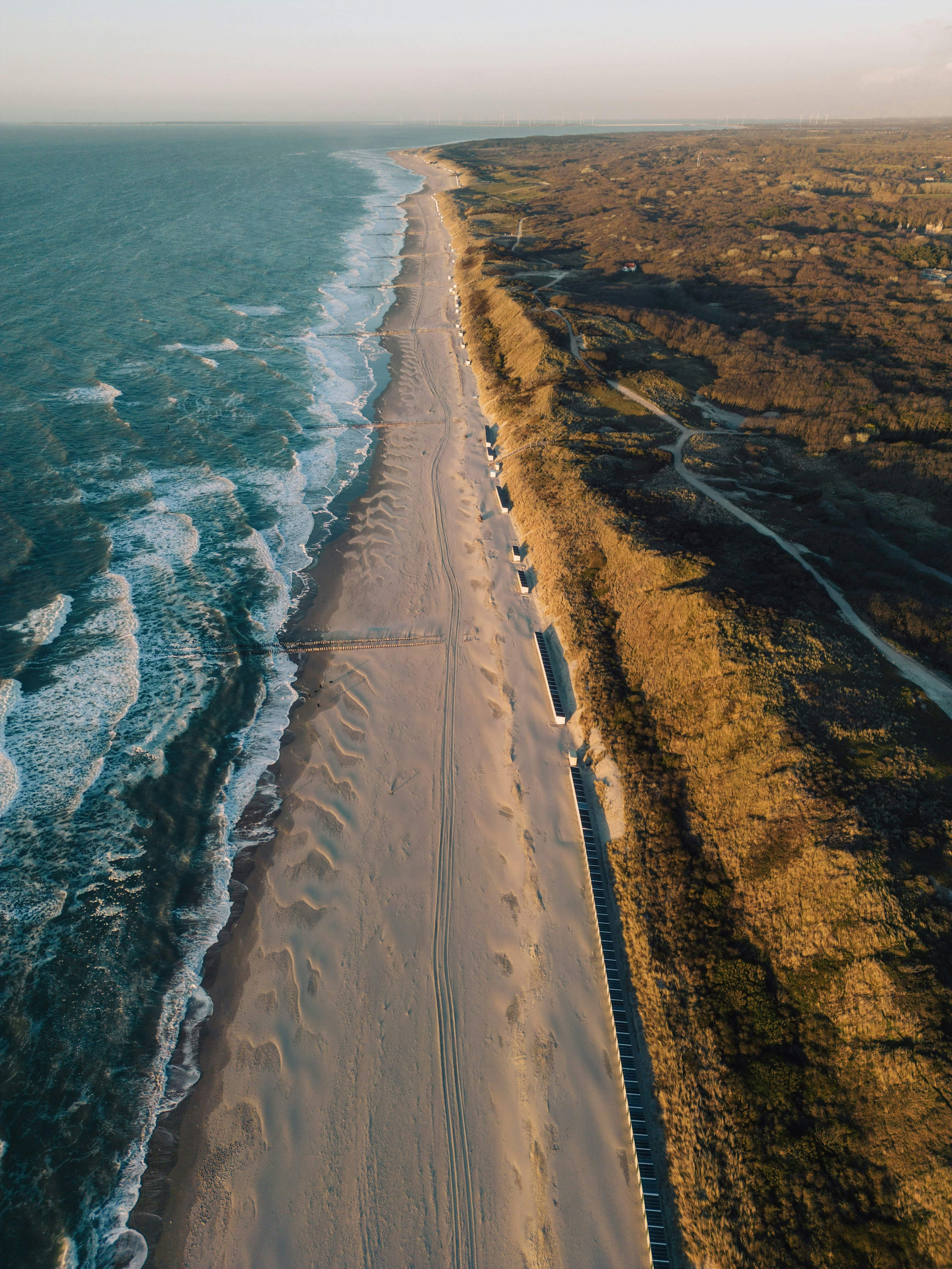 Aerial Crest: Sunset over sand and dunes along the windswept coast