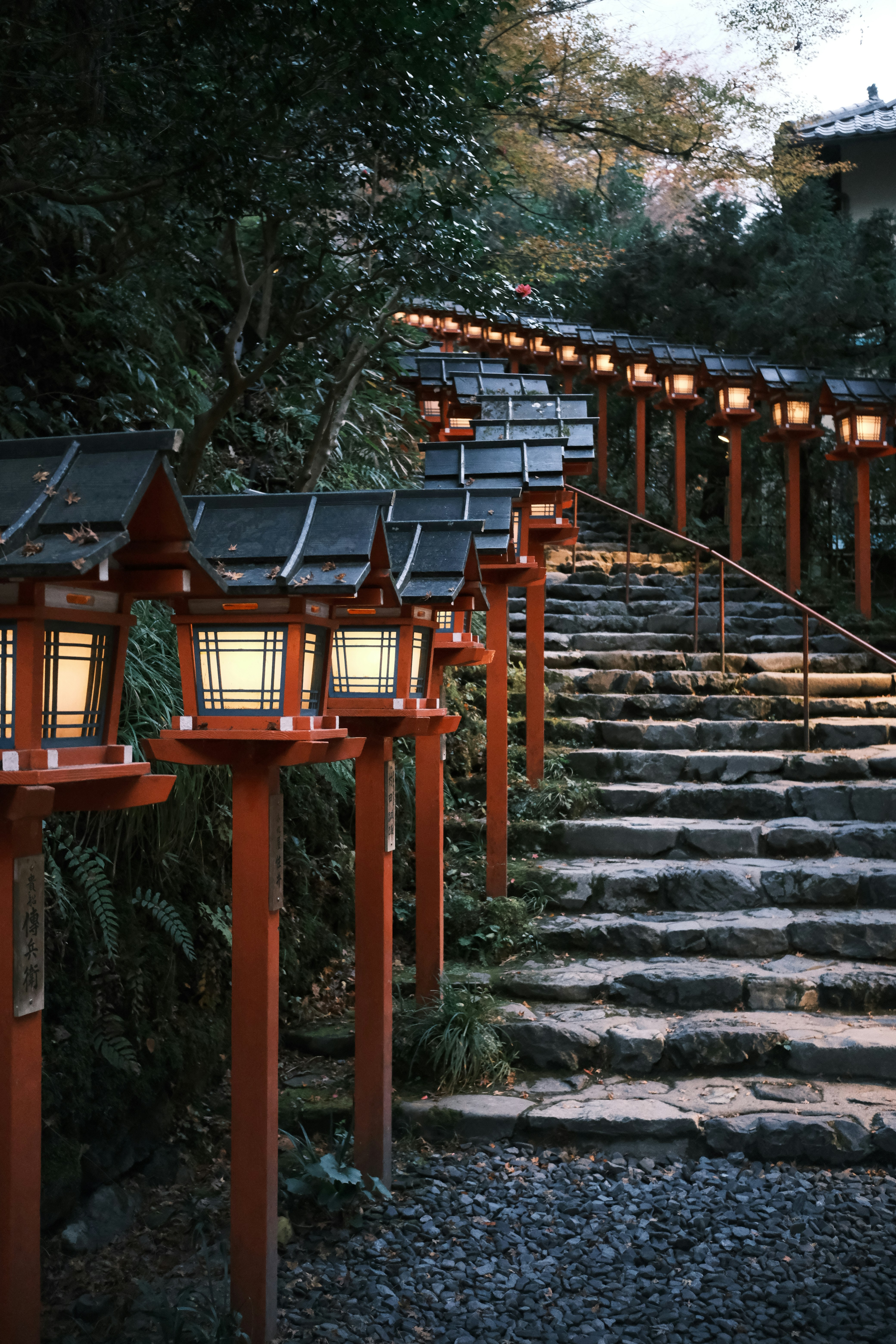 Evening Lantern Walk Through a Red Torii Corridor