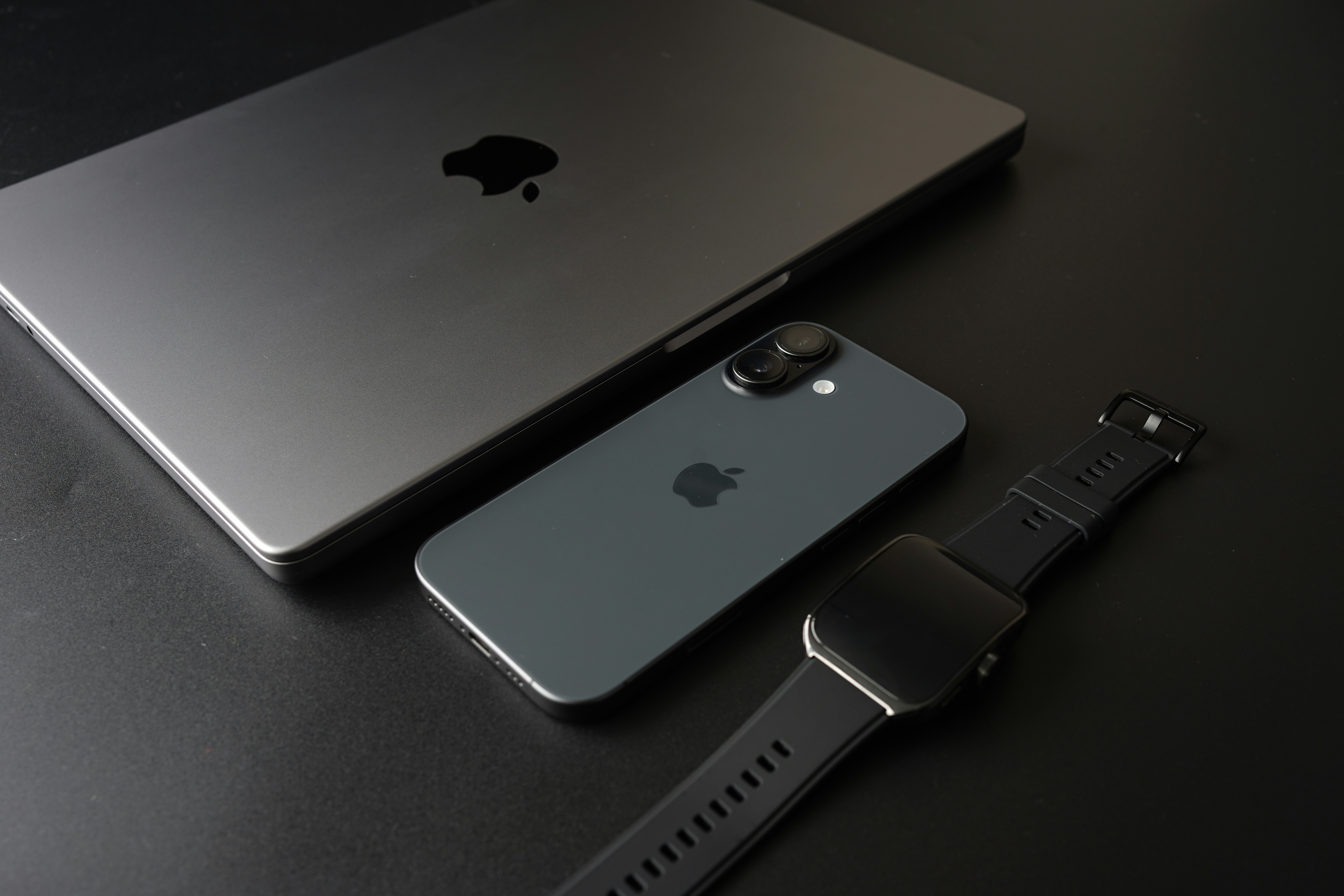 Silhouettes of a MacBook, iPhone, and Watch: Quiet Tech Ensemble