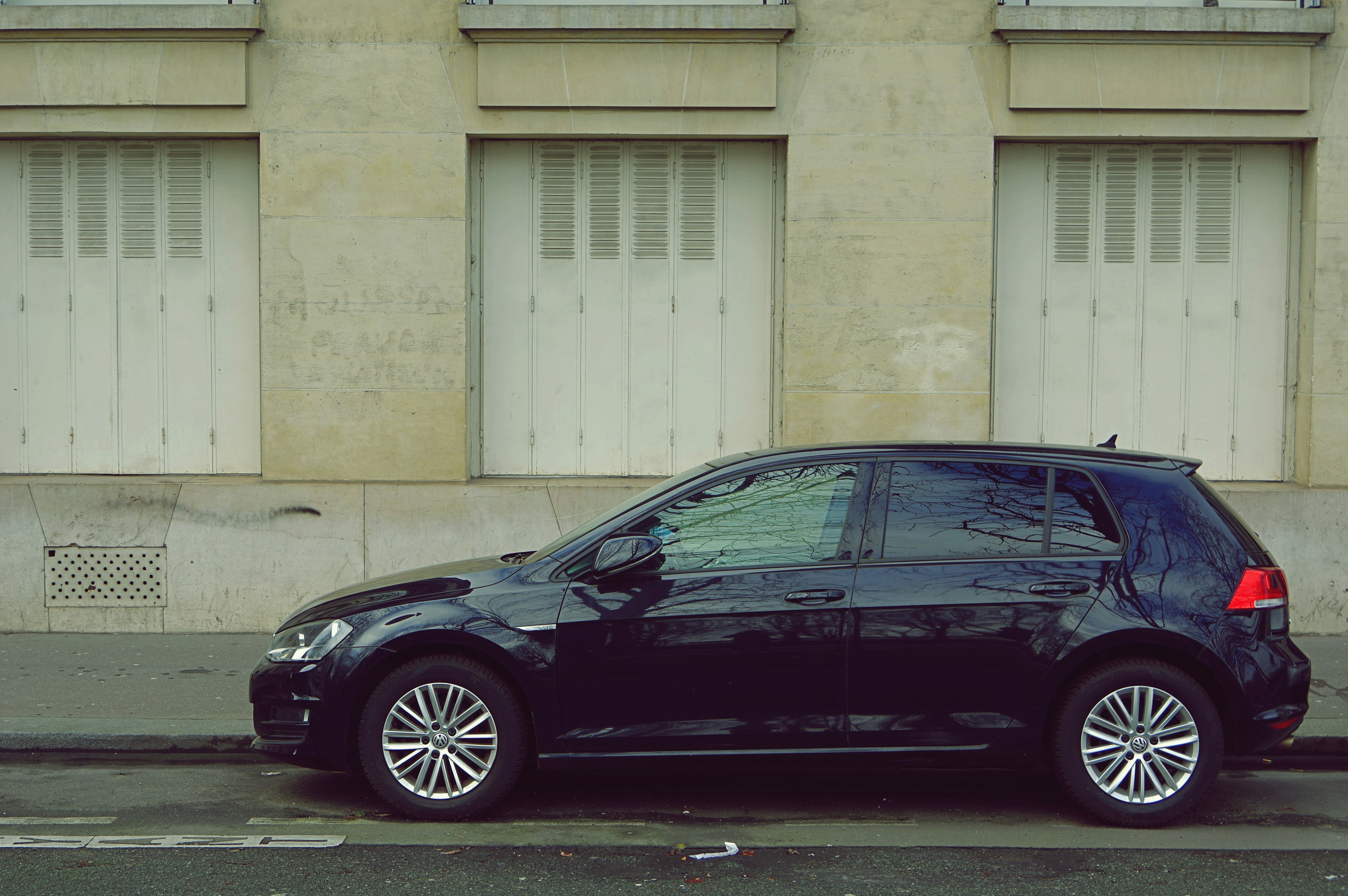 Midday Glide: A Black Hatch Resting Along a Quiet Street