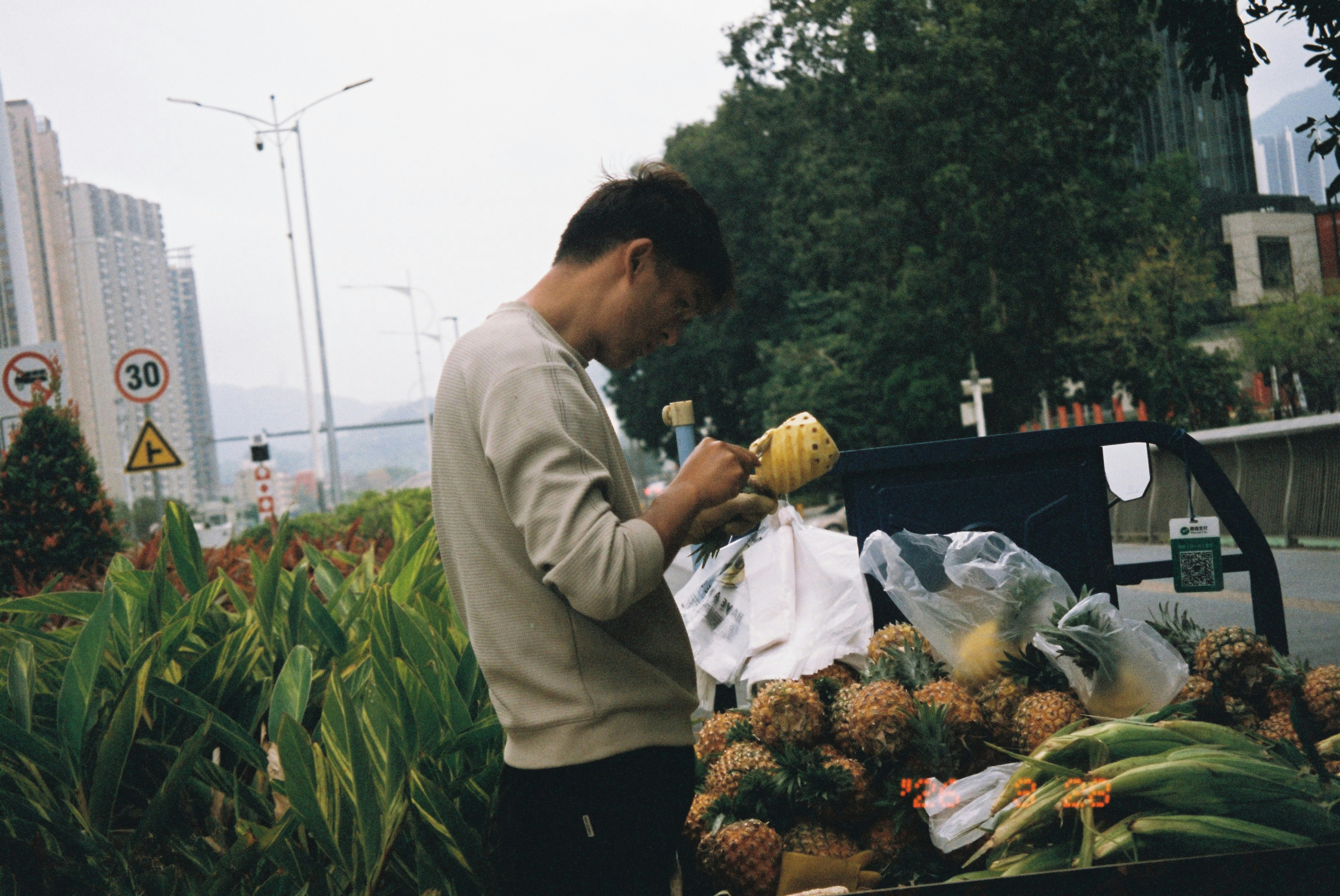 Man selecting fruit at a bustling street-side stall
