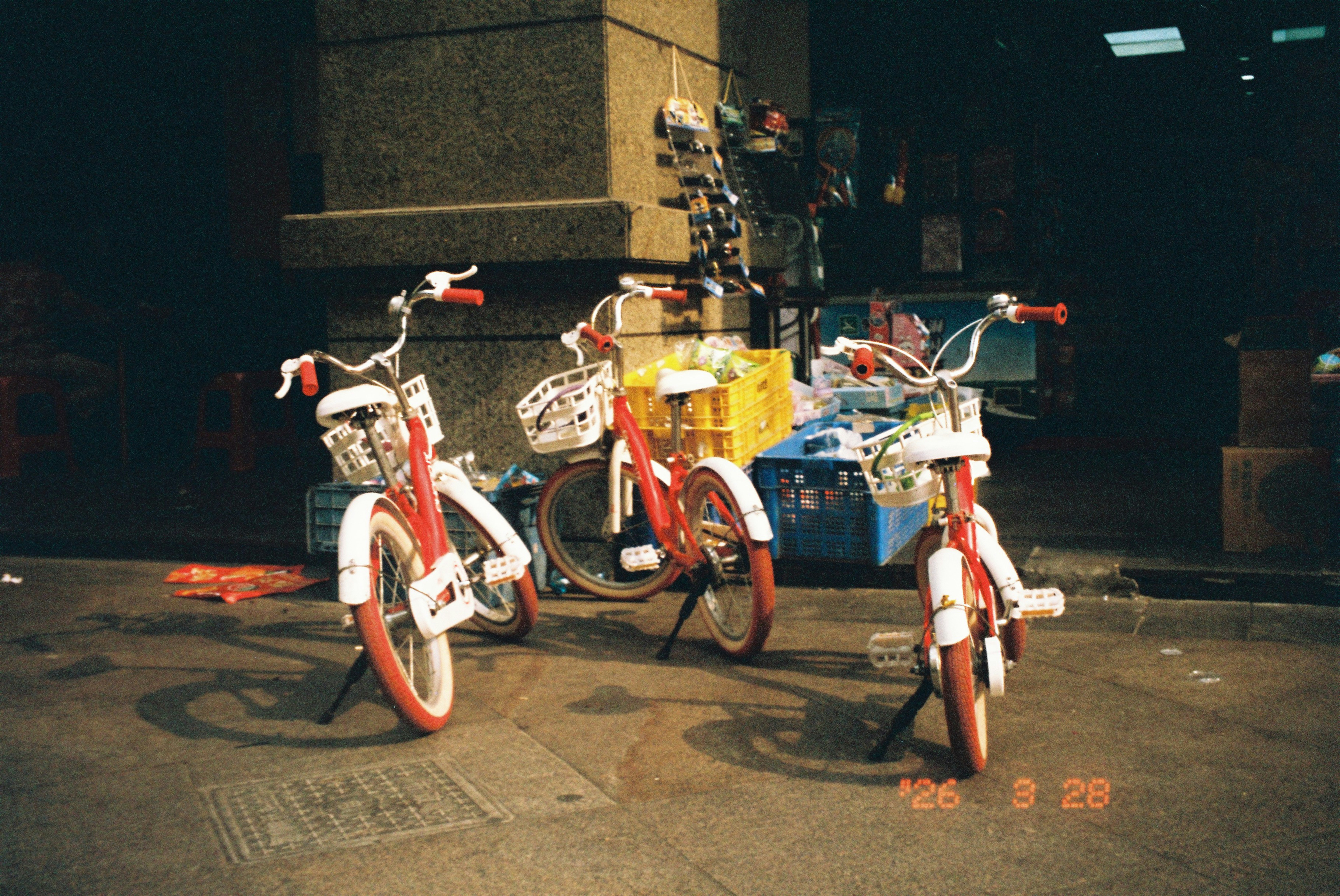 Three Pediatric Bicycles Rest in a City Market Stall