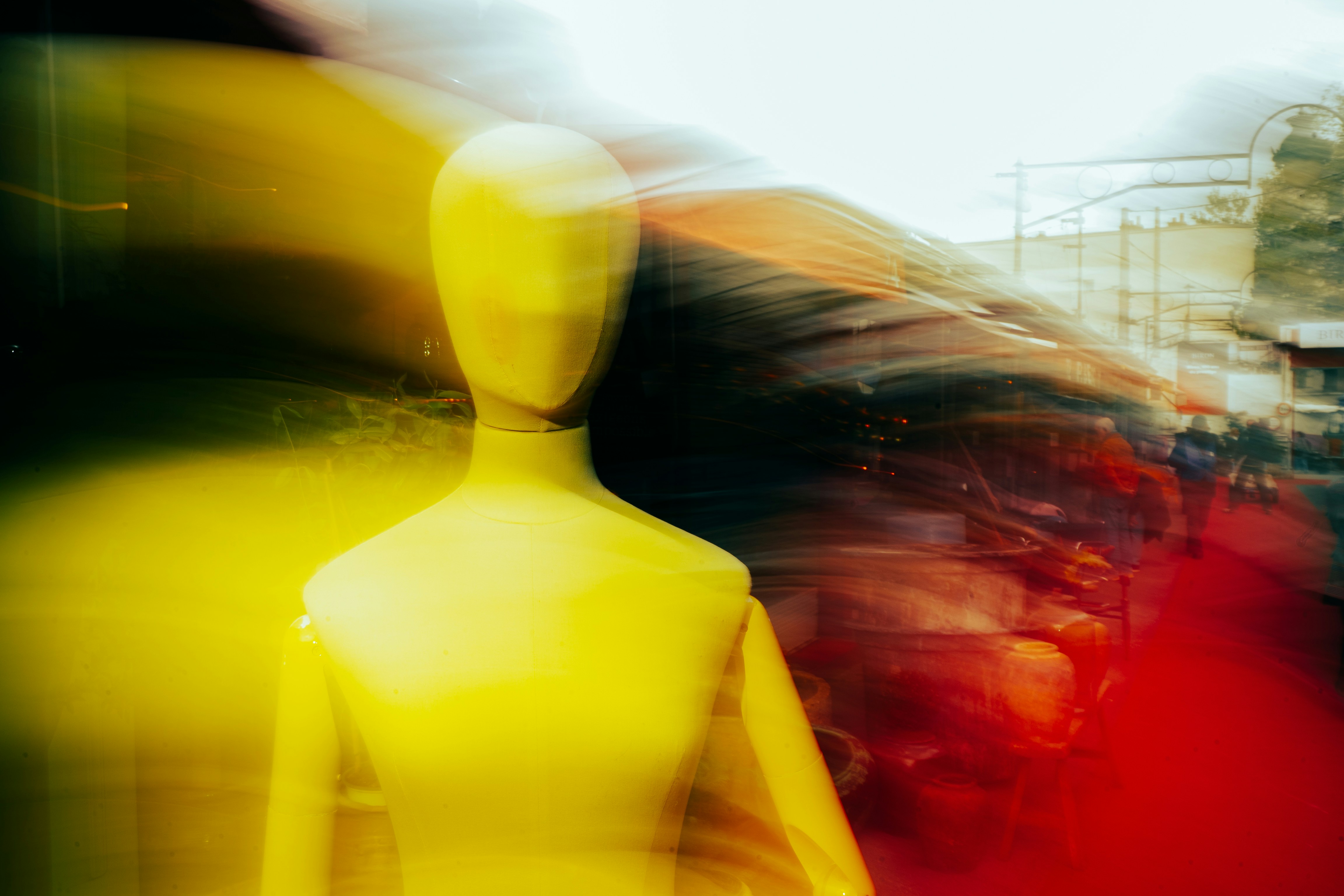 Yellow mannequin in motion blur among rushing color trails