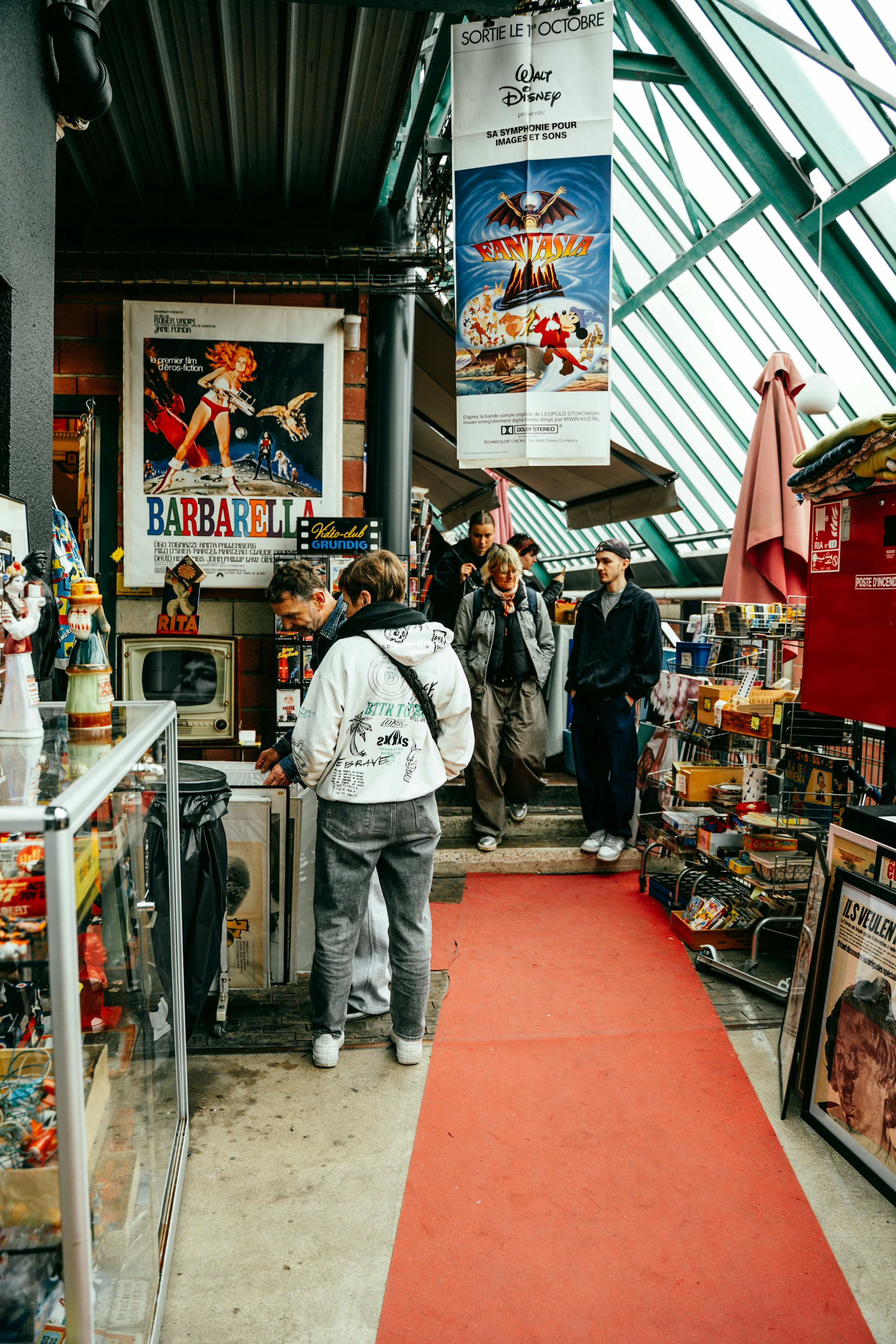 Collectors' Alley: A Poised Crowd Beneath Vintage Posters