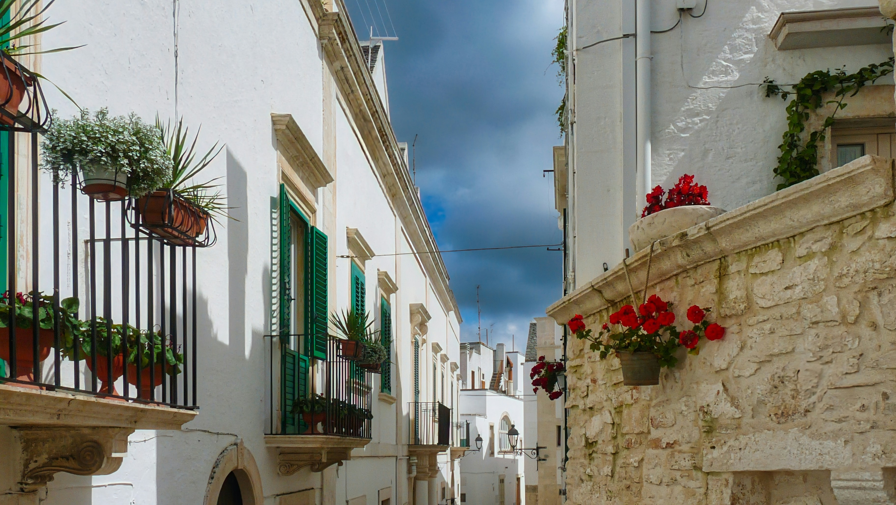 Whitewashed Mediterranean Alleyway Framing with Green Shutters