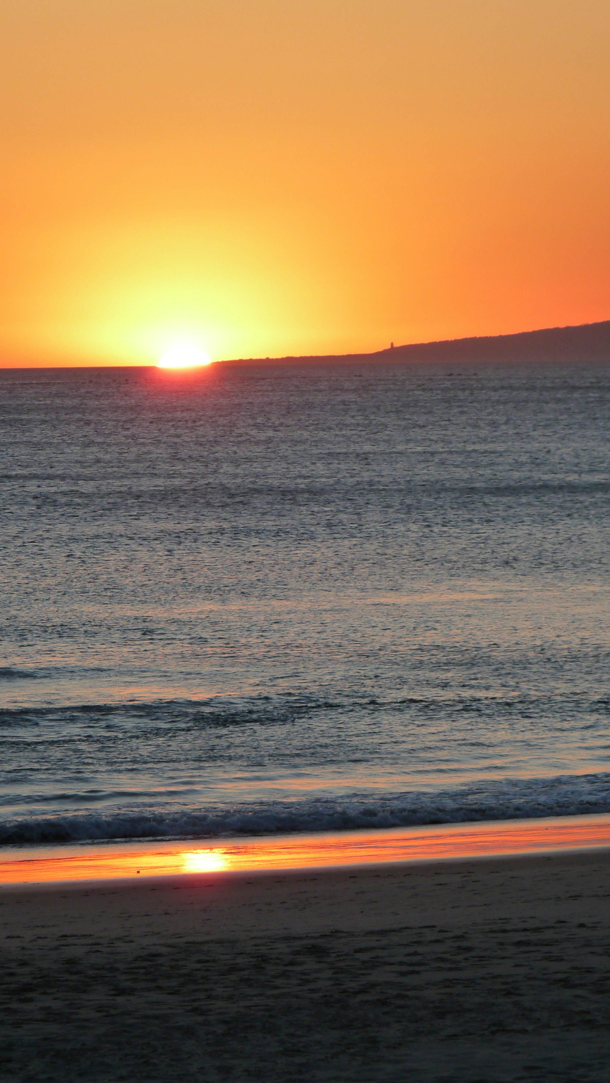 Sunlit Shoreline: The Final Glimmer Over a Quiet Sea