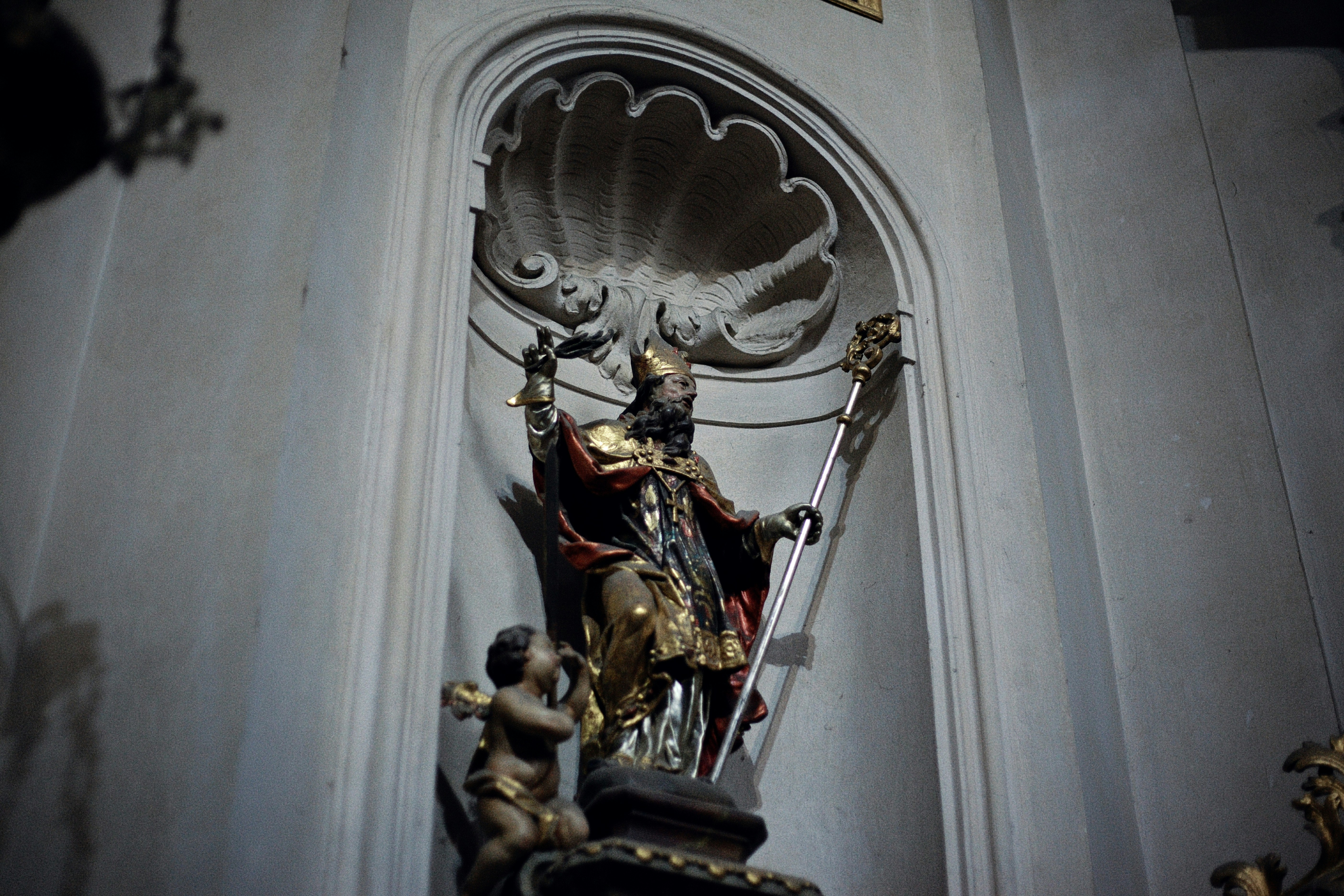 Saintly Figure in Ornate Niche: Golden Robes and Scepter Reach Skyward