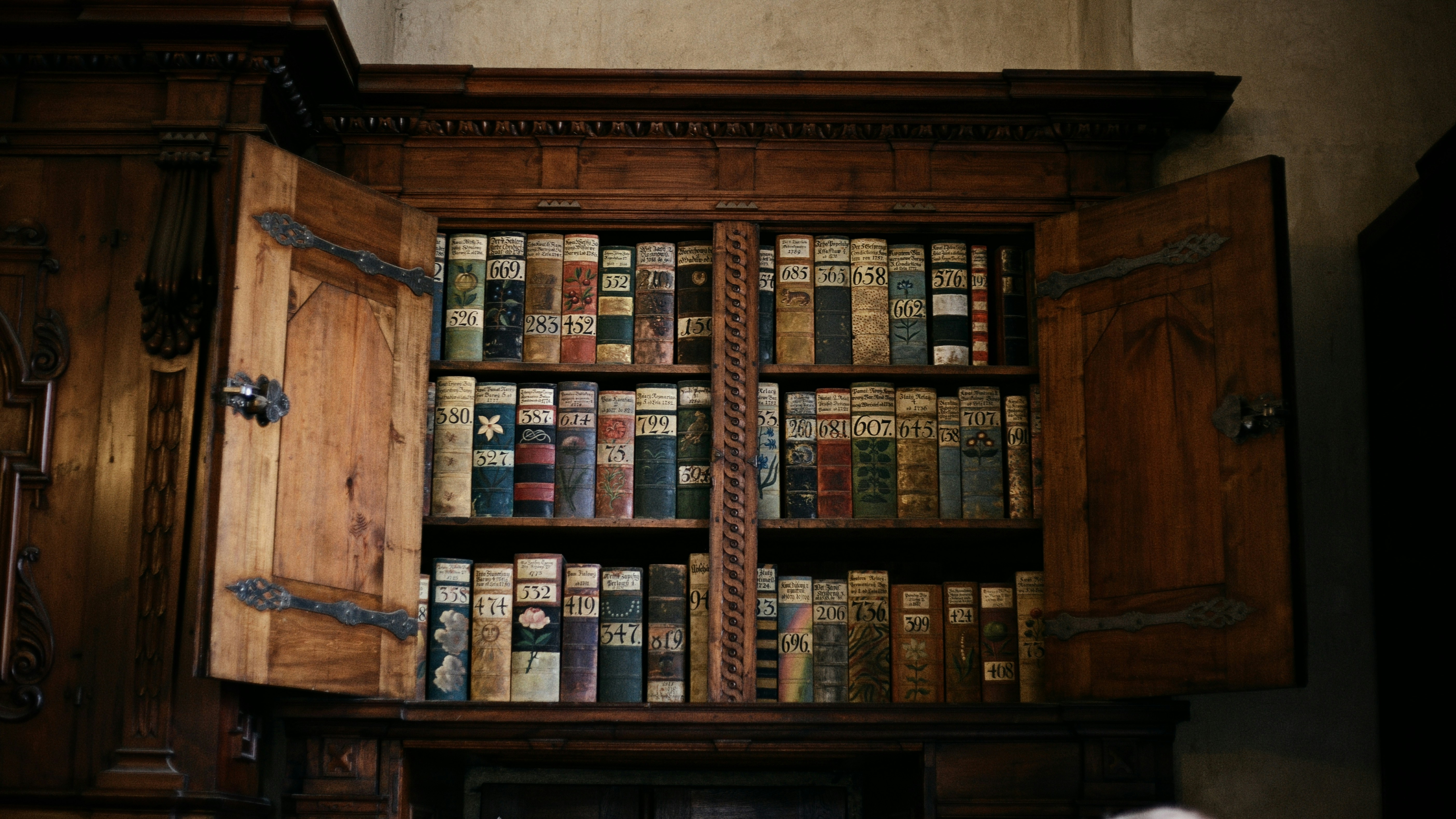 Open Antique Cabinet: a wall of weathered leather-bound volumes