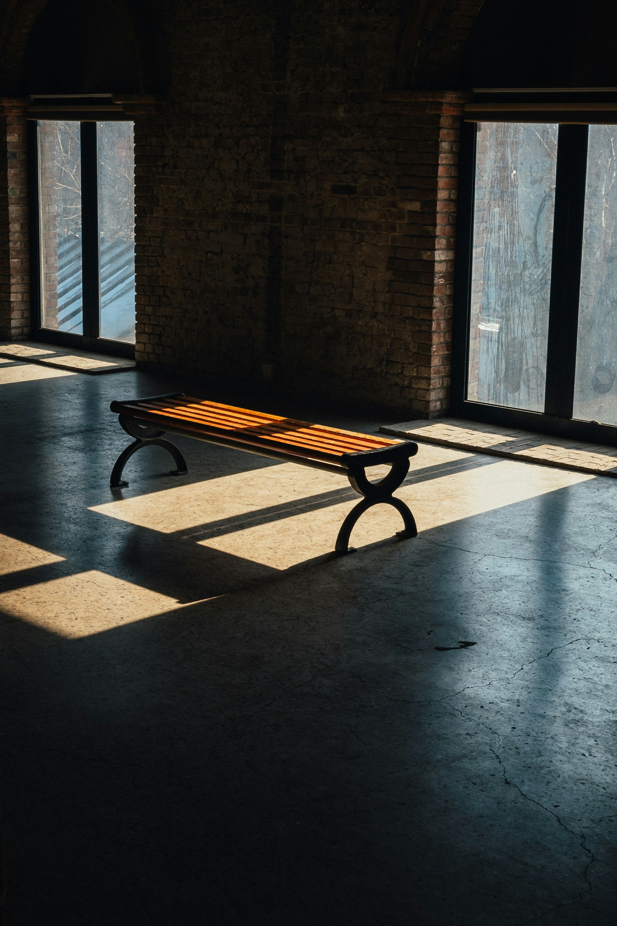 Sunlit Bench in a Quiet Brick Corridor