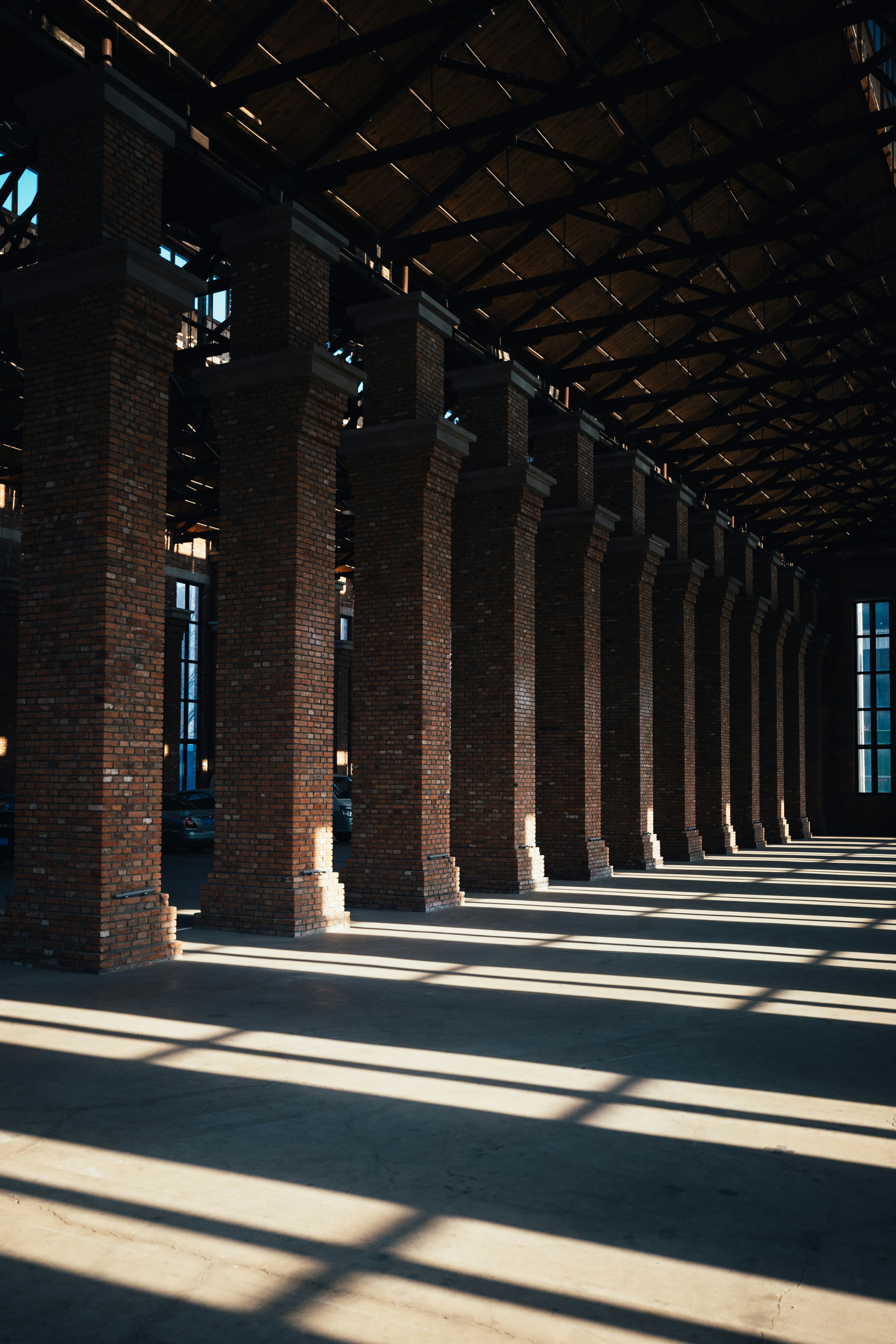 Columns of Light: Sunlit Rails in a Brick Hall