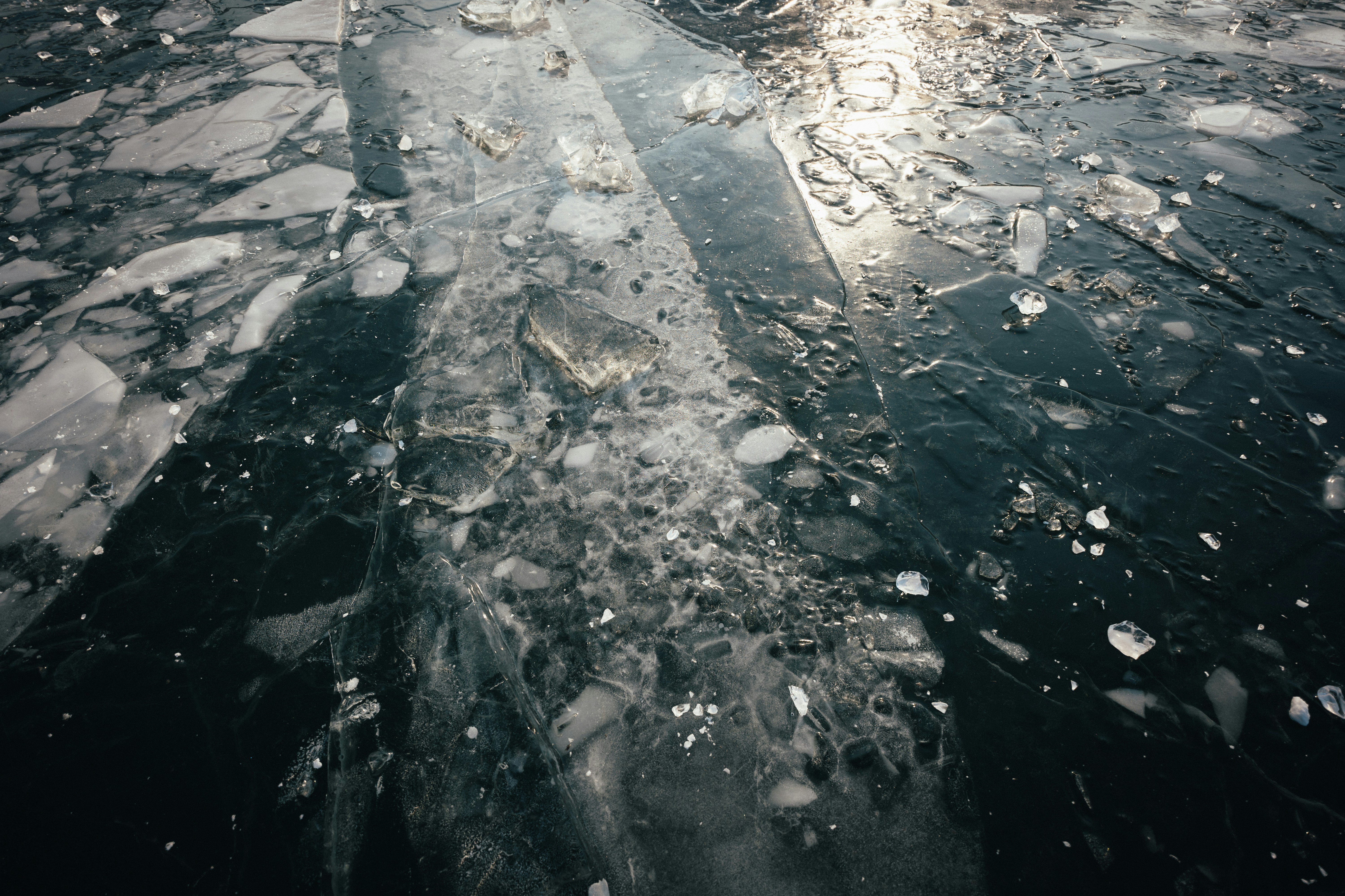 Fractured Ice Road: Sunlit Slabs on a Dark Coastal Surface