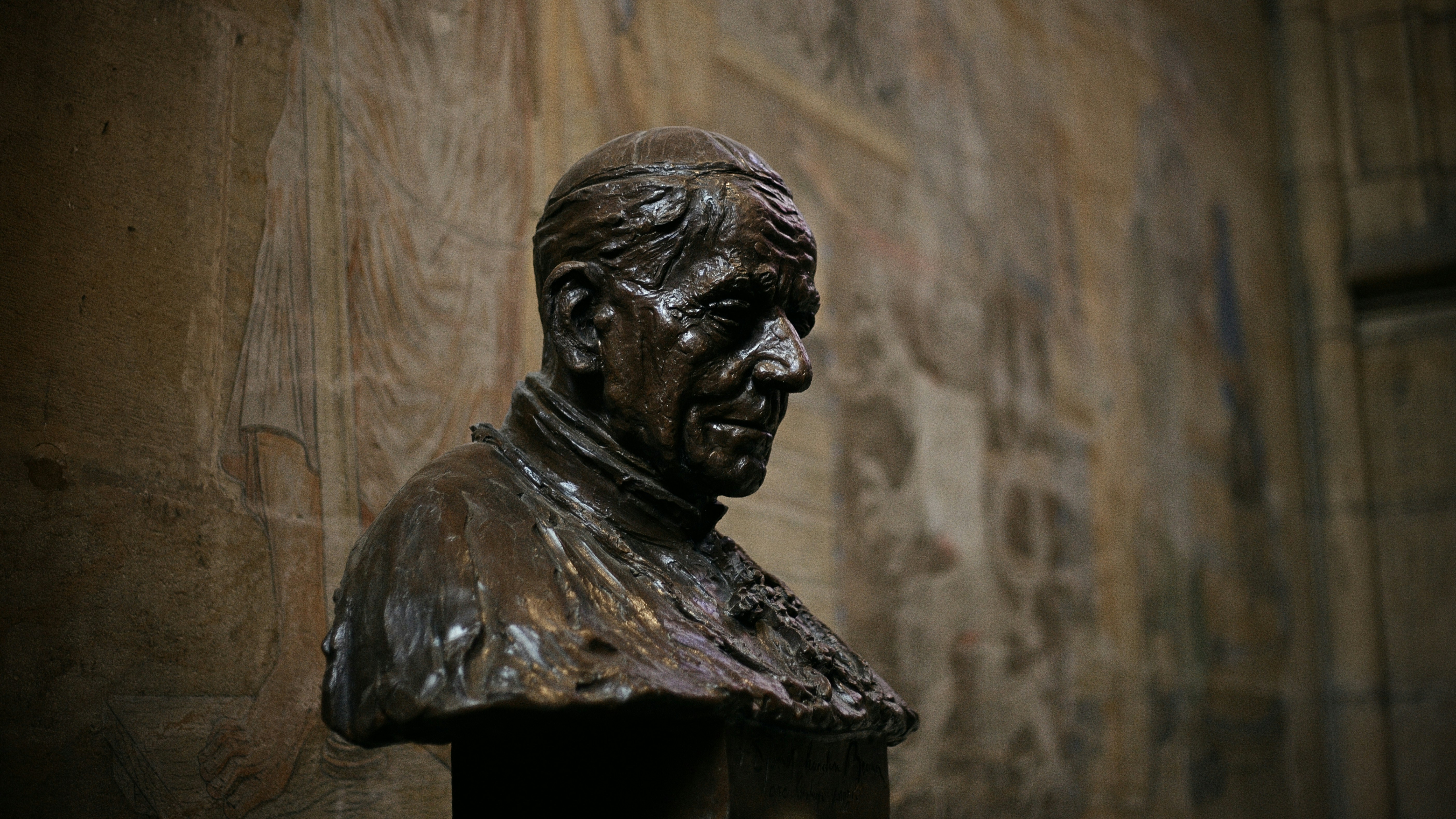 Bronze Whisper: A Weathered Bust Beneath Stone Shadows