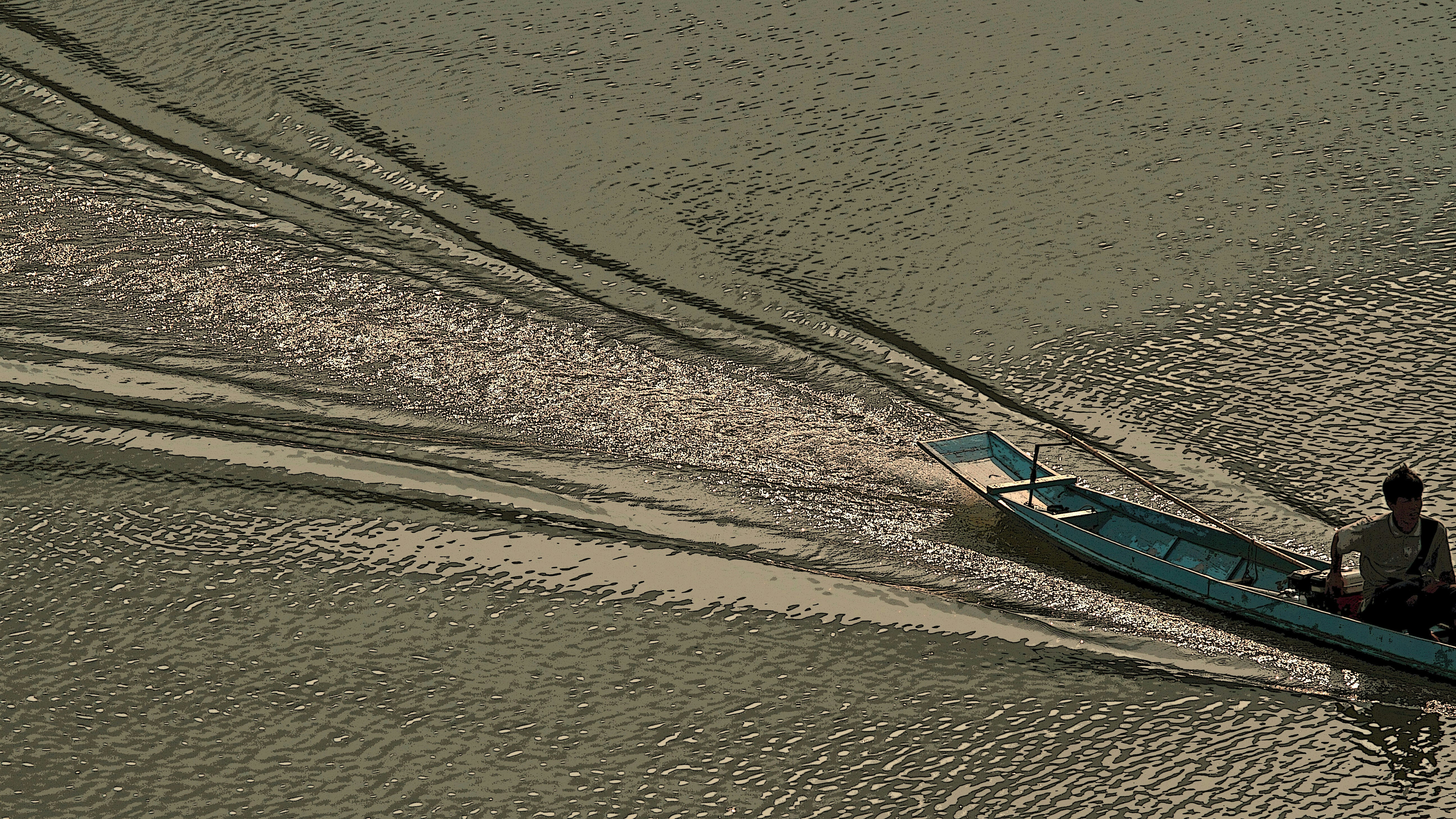 A solitary boat carves a wake across amber-tinted water