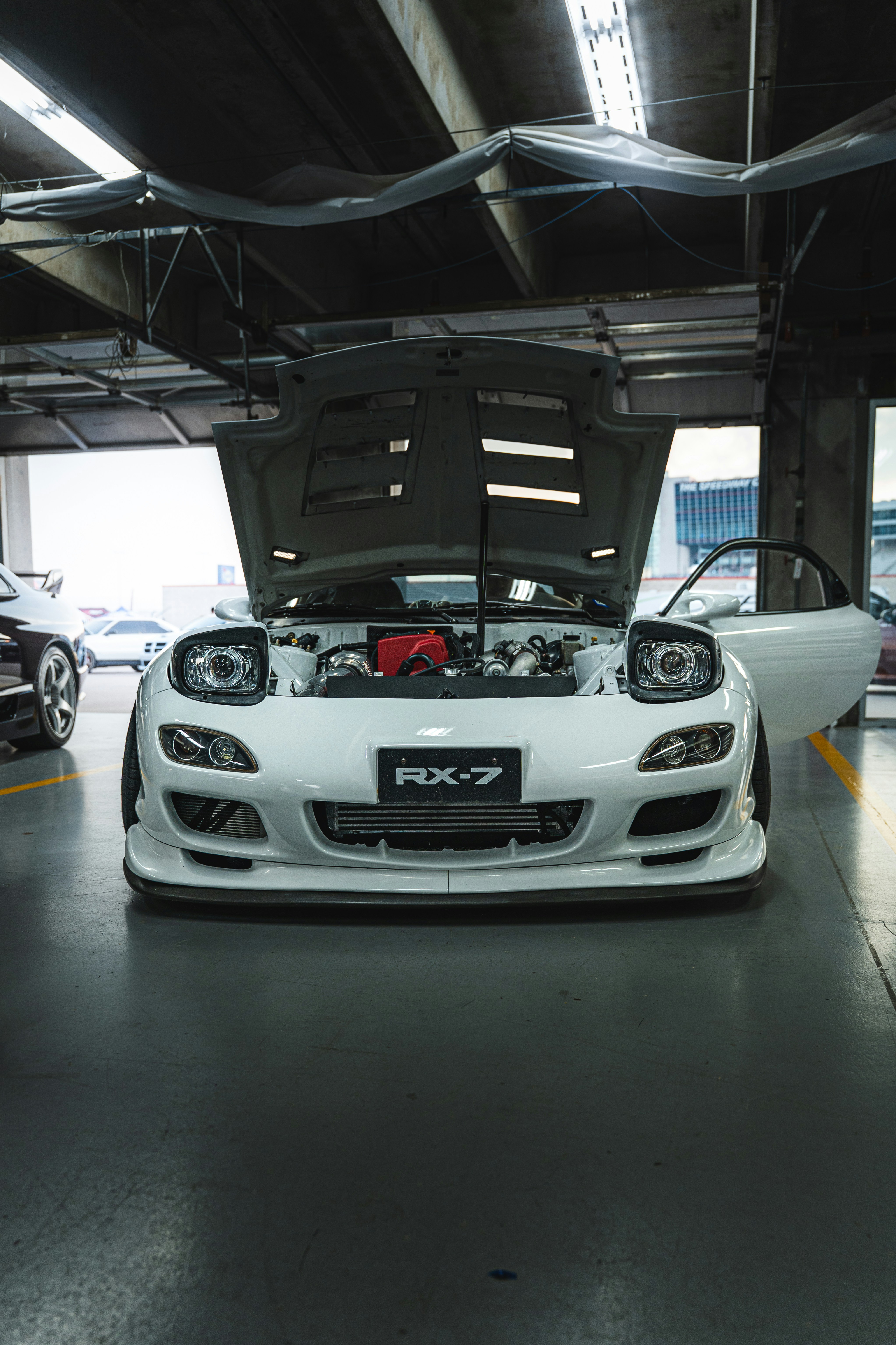 White RX-7 Under Neon Veil: Engine Bay Spotlight