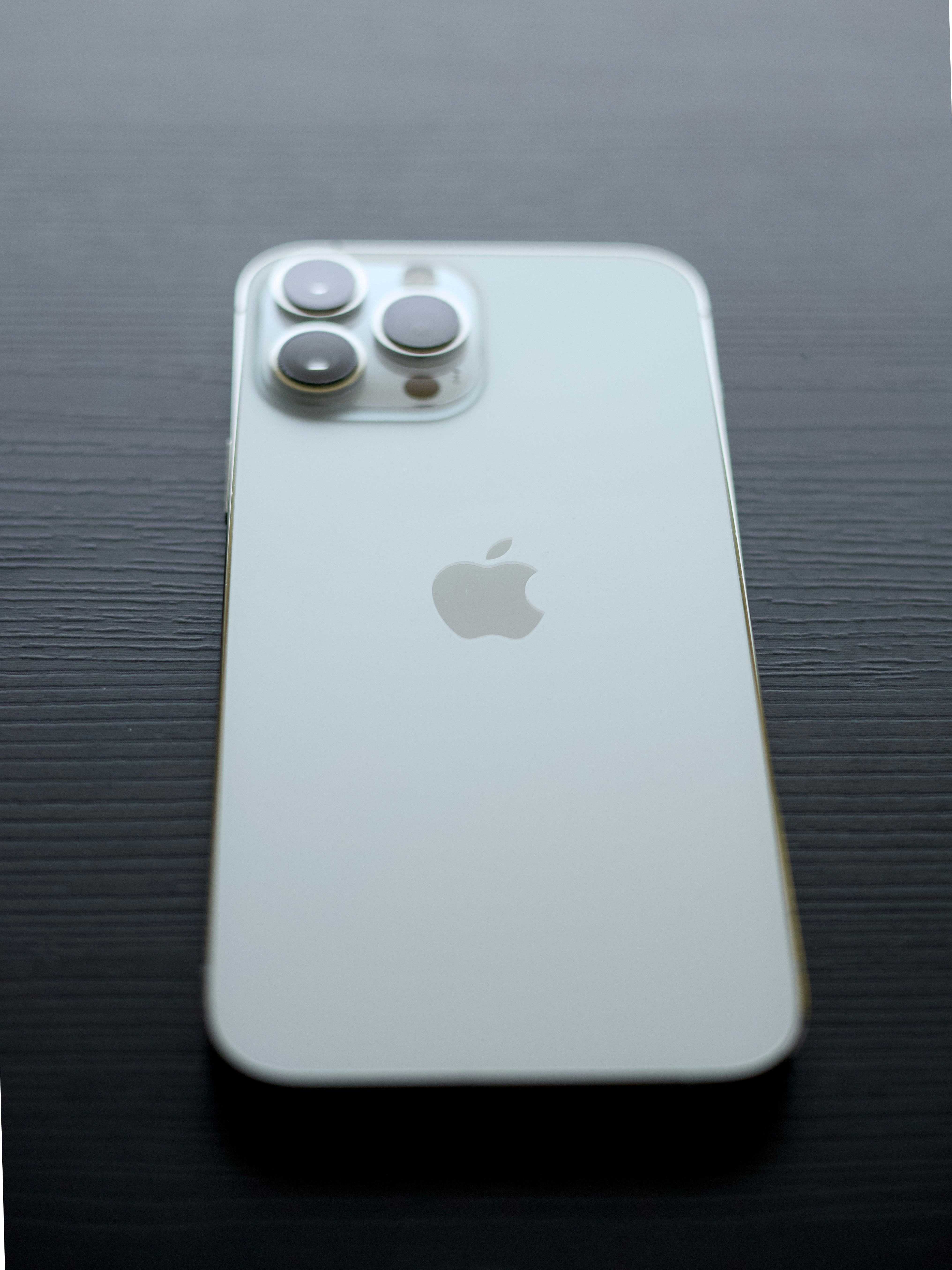 Apple iPhone on a dark wooden surface with a soft centered glow