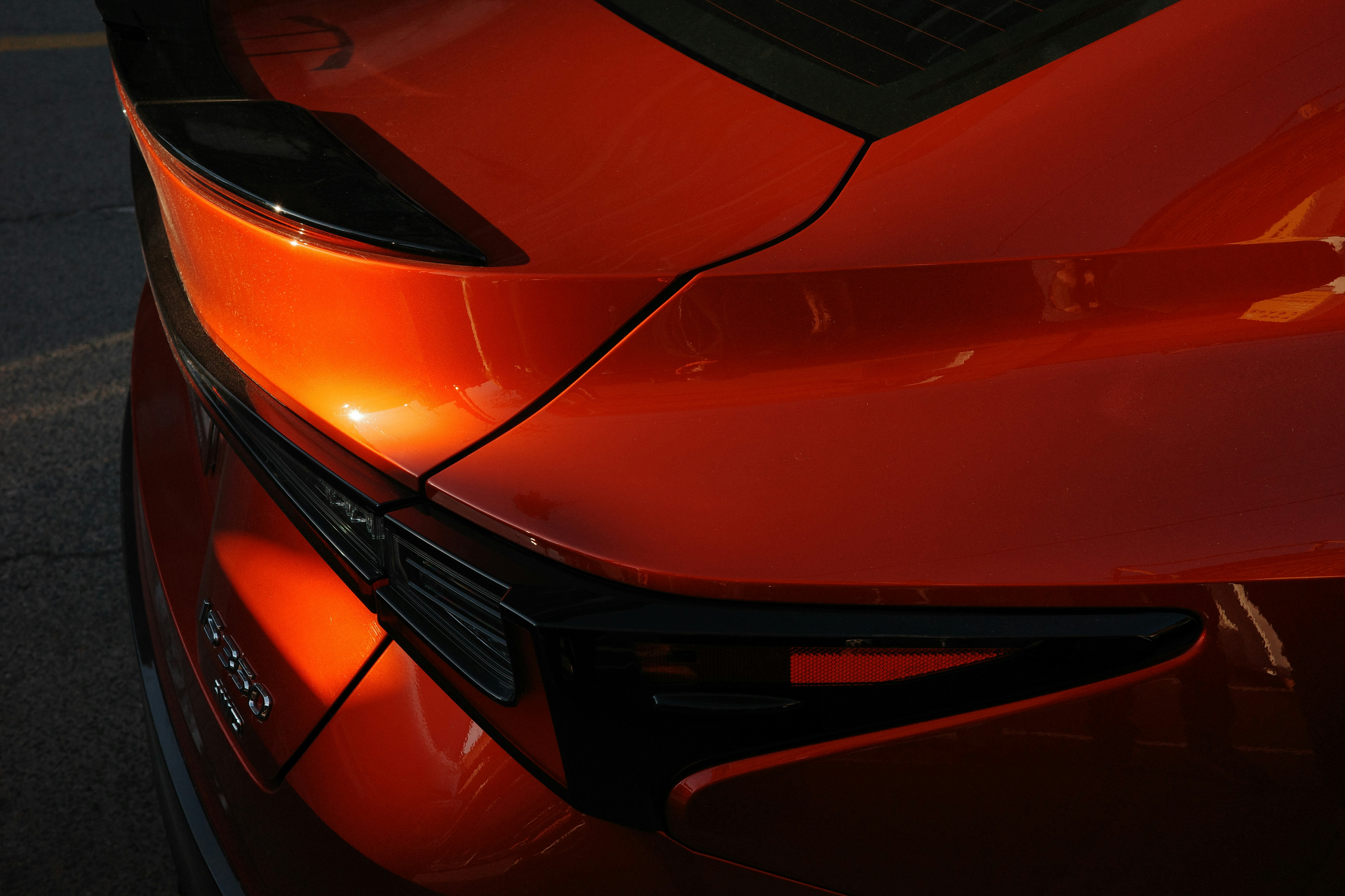 Crimson Curves: Close-up of the Car’s Front End at Dusk