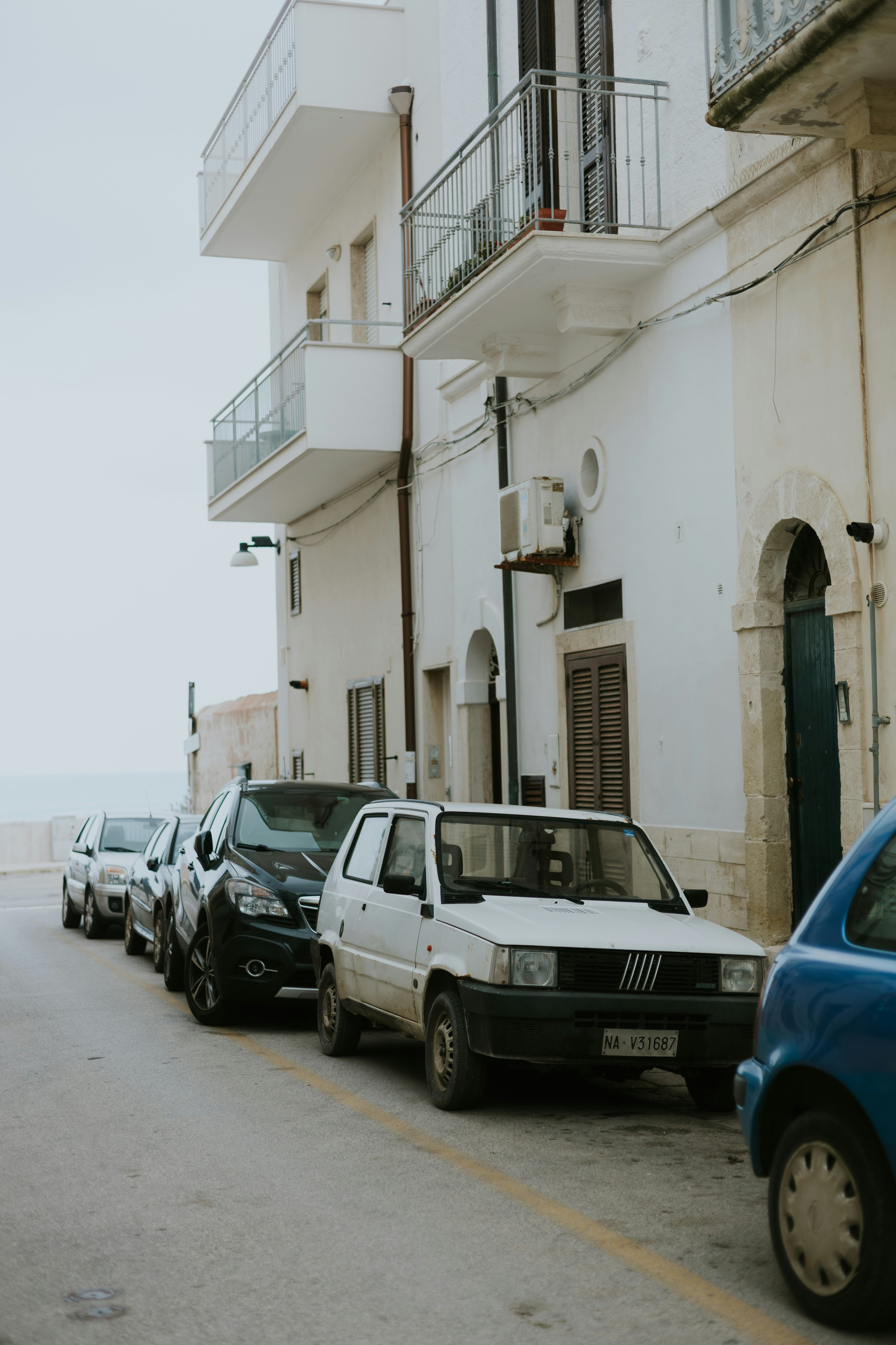 Coastal Street Calm: A Row of Cars and White Facades