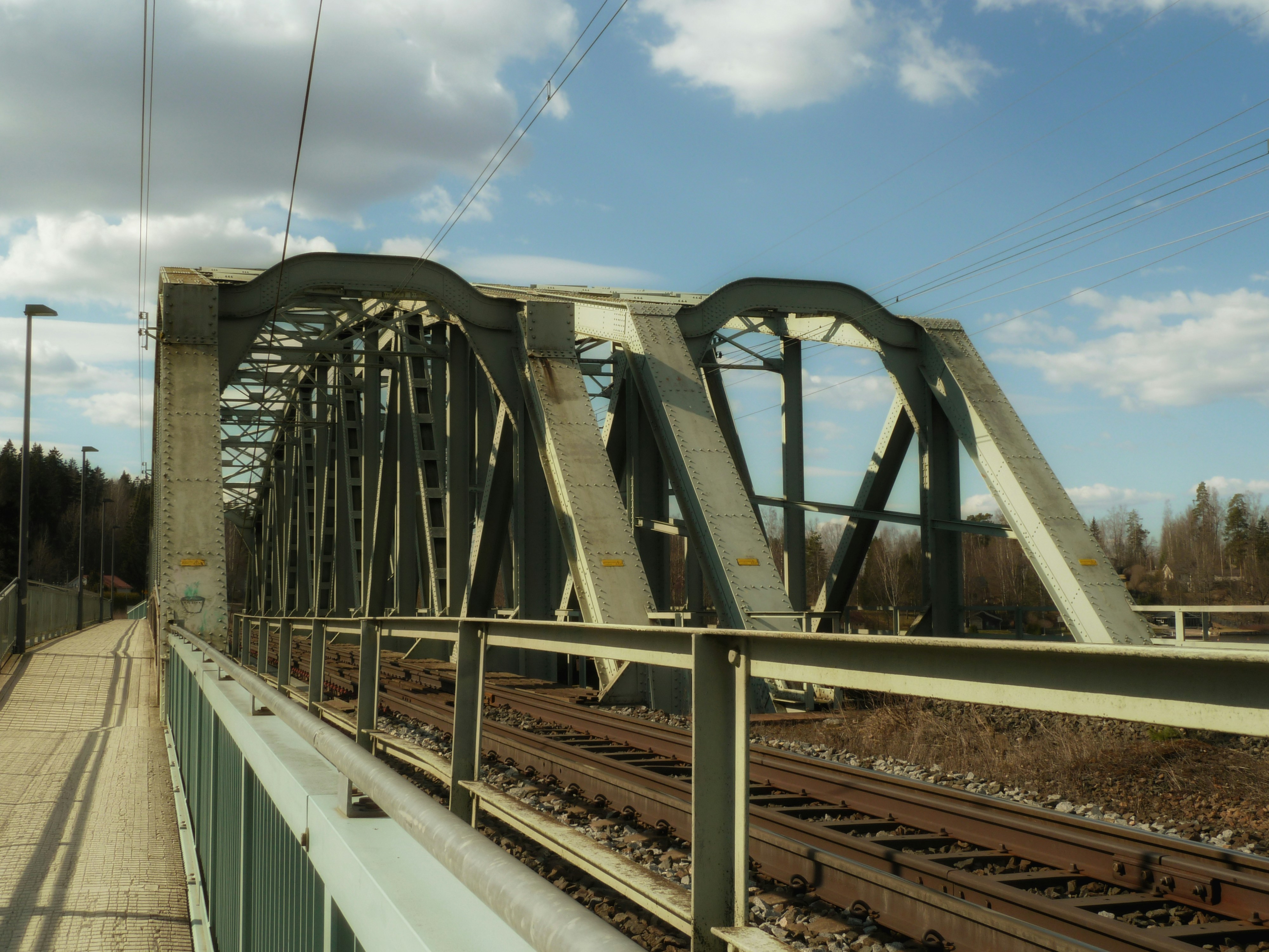 Steel Arcway Over Tracks: A Quiet Bridge in Afternoon Light